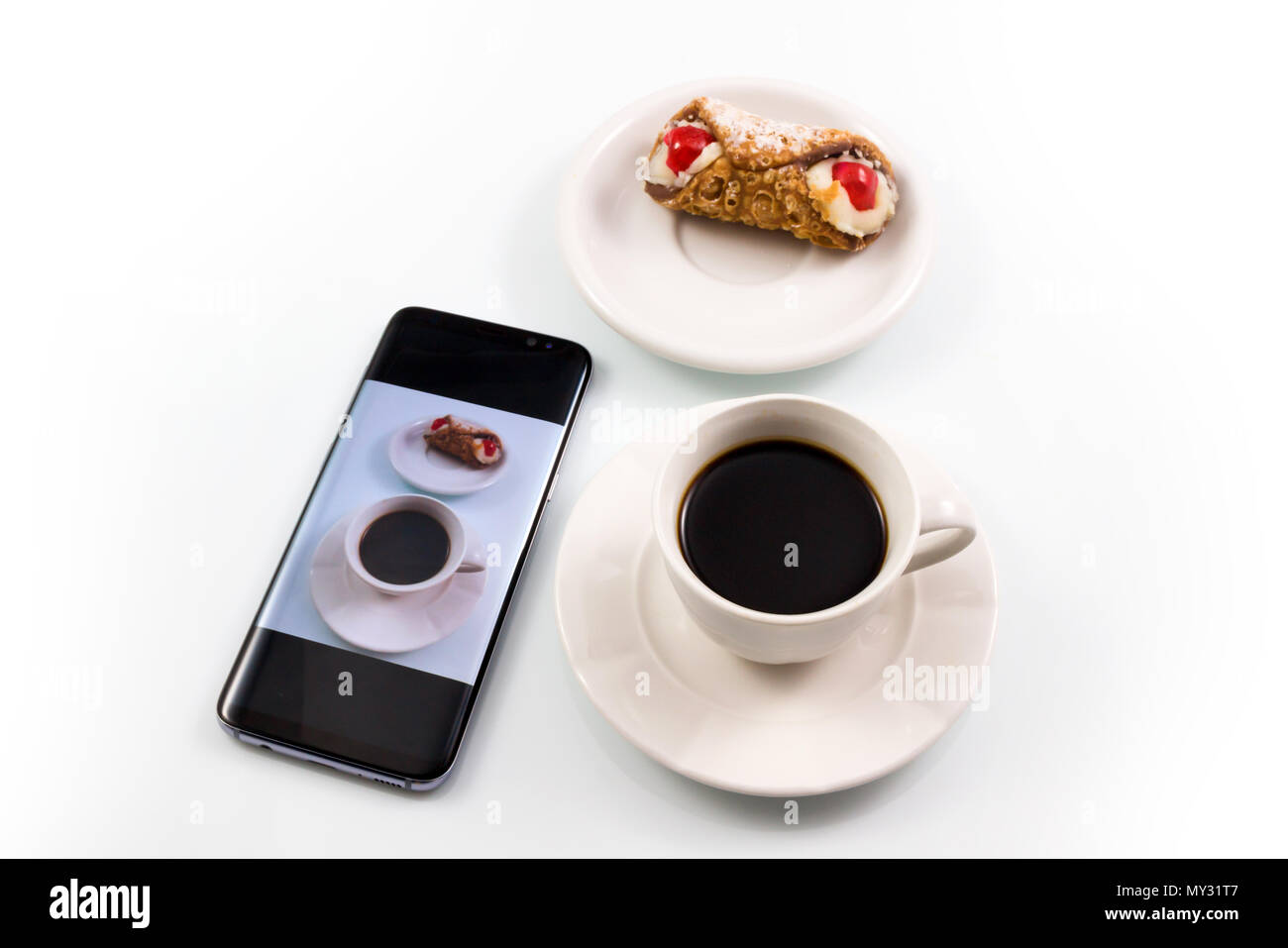 Picture coffee and sweet cookie with a smartphone in white background ...
