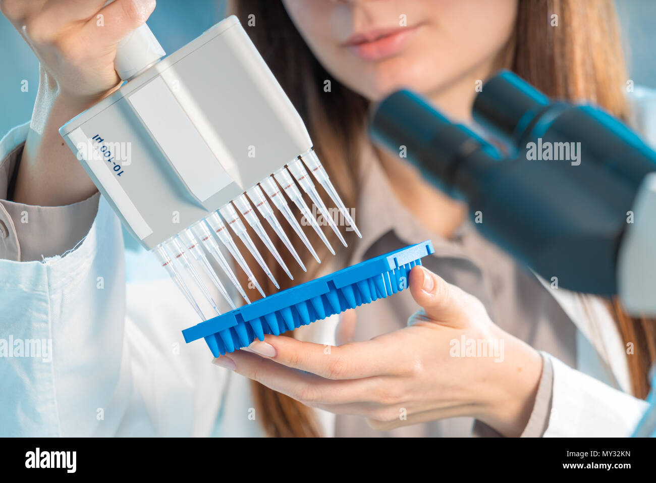 student woman with multi pipette and other PCR items in microbiological ...