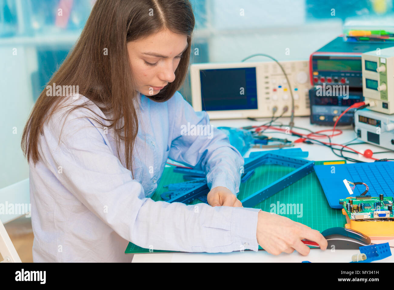 Female student in electronics class uses a Measuring device Stock Photo ...