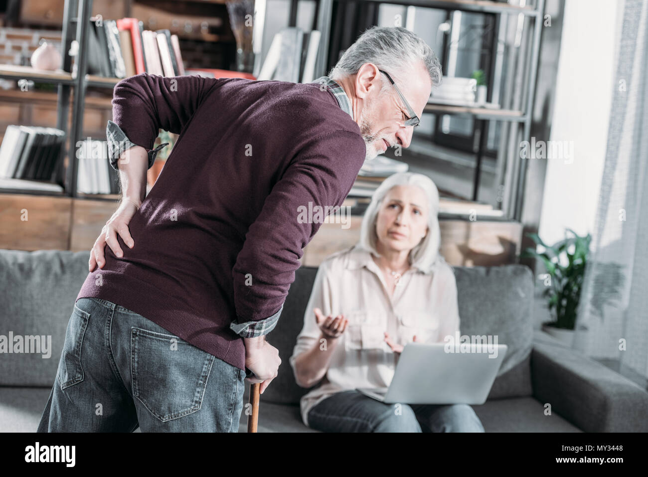 side view of senior man suffering from strong back pain Stock Photo - Alamy