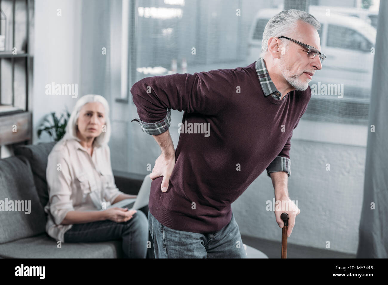 side view of senior man suffering from strong back pain Stock Photo - Alamy