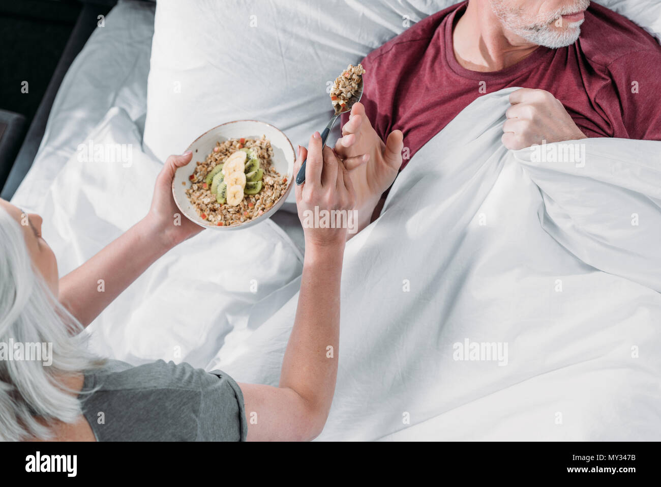 partial view of woman taking care of sick husband in bed at home Stock ...