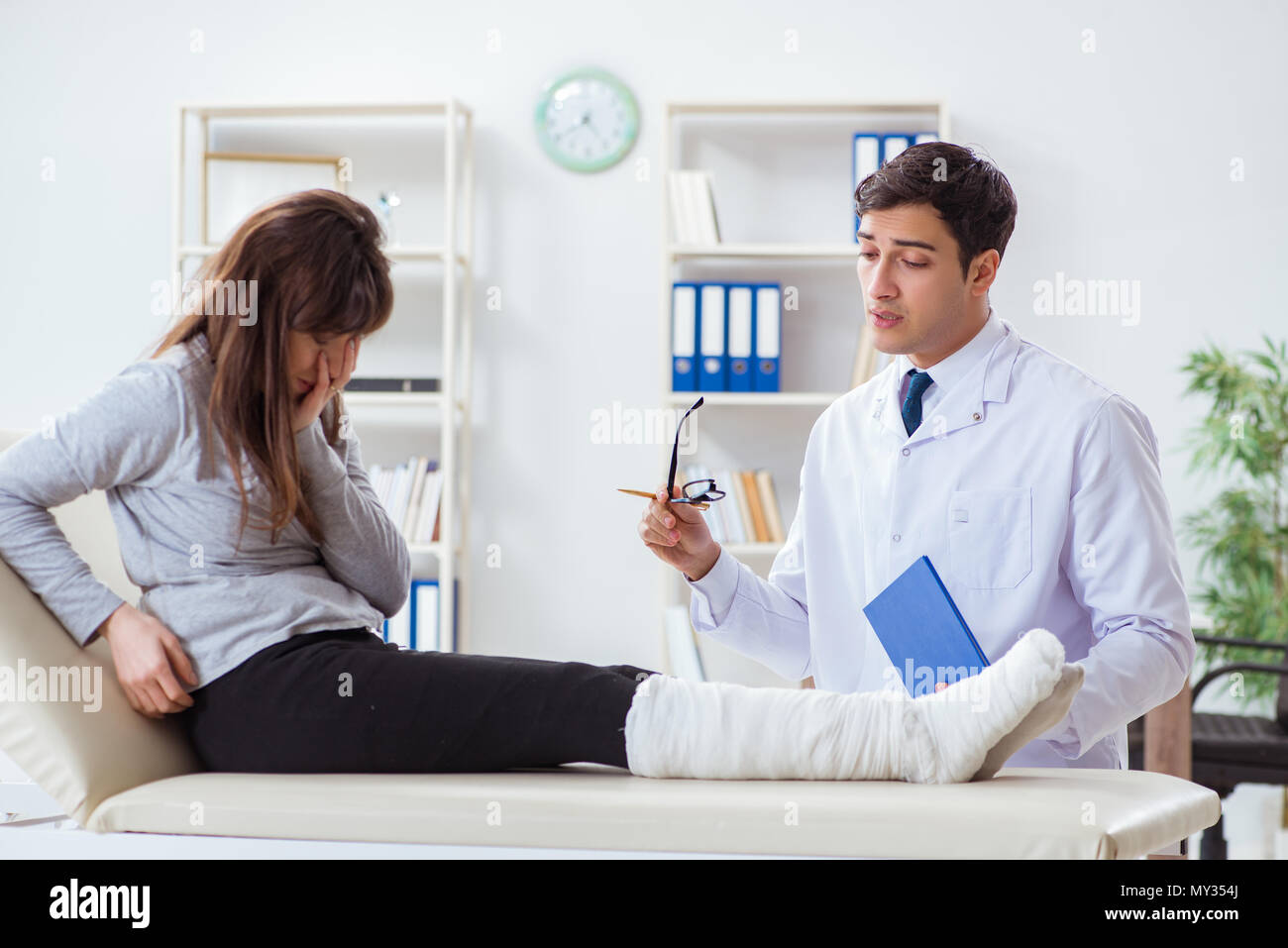 Doctor examining patient with broken leg Stock Photo - Alamy