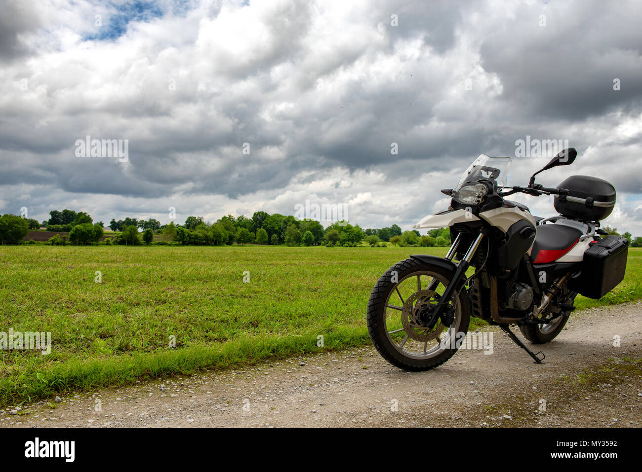 a motorcycle on a path with a cloudy sky Stock Photo - Alamy