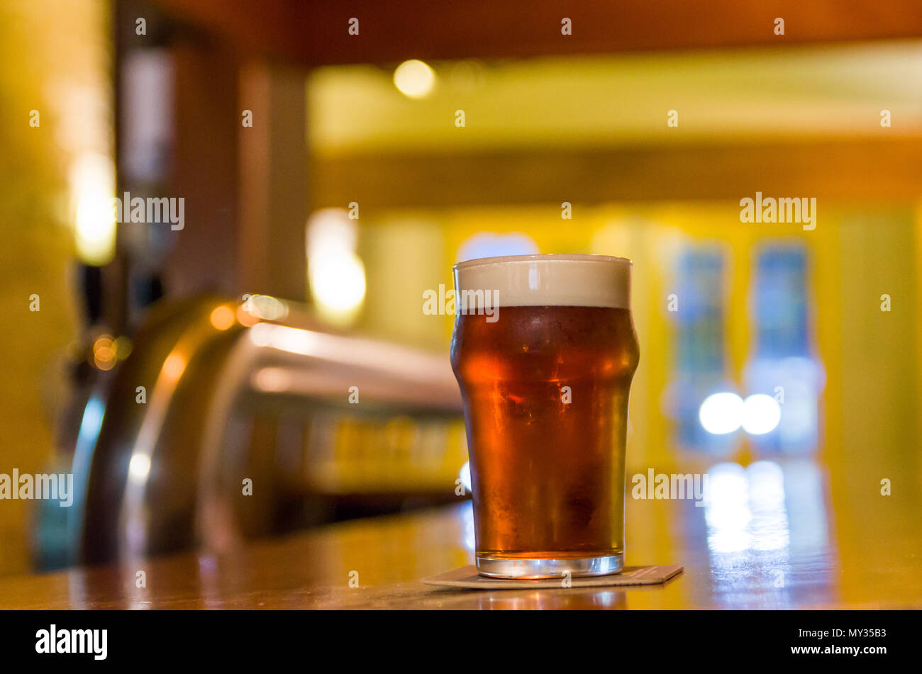 Glass pint of beer on top of bar counter, brewpub, craftbeer Stock ...