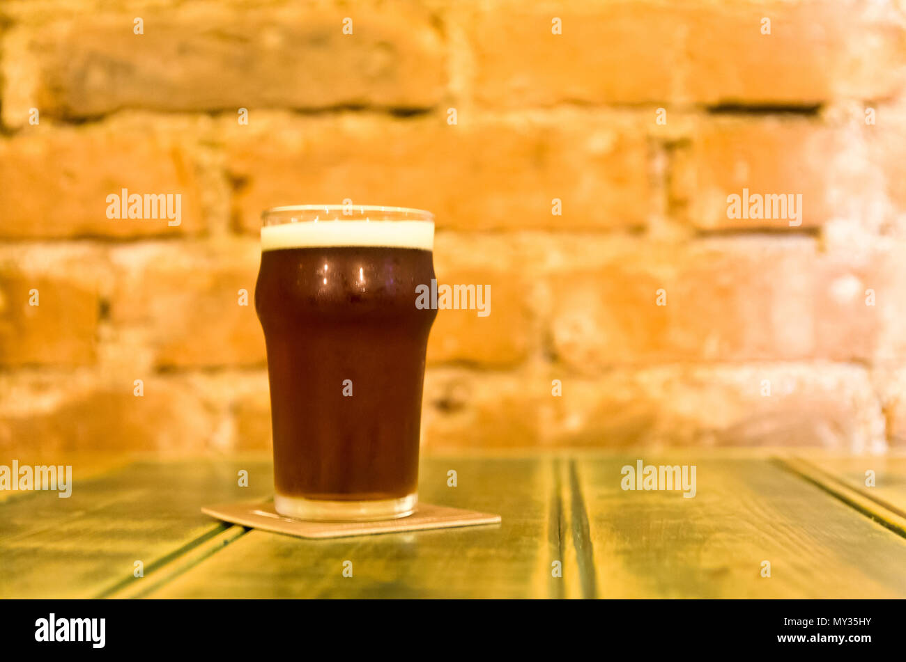 Glass pint of beer on top of bar counter, brewpub, craftbeer Stock ...