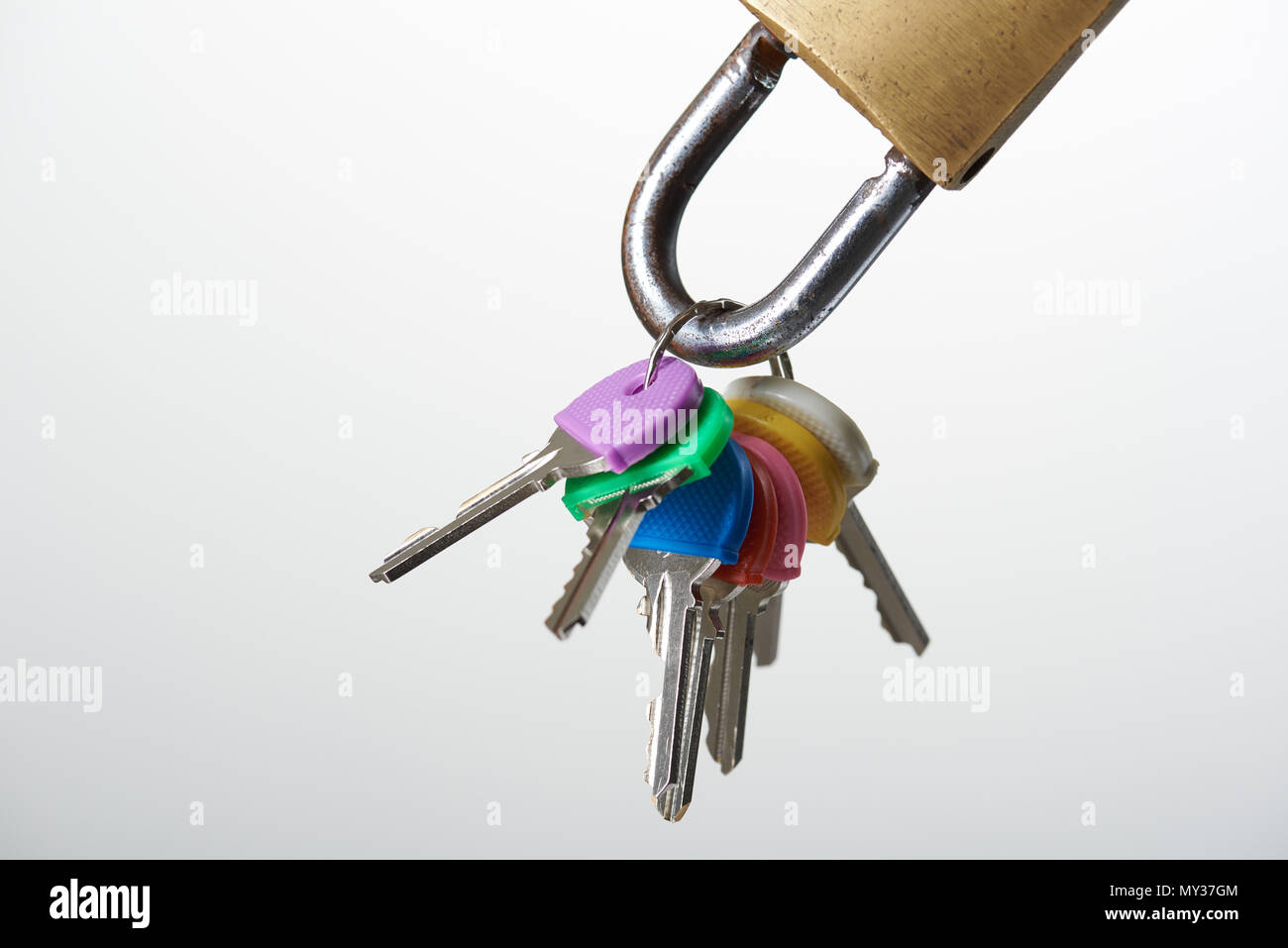 Keys hanging on metal lock isolated on white background close-up view ...