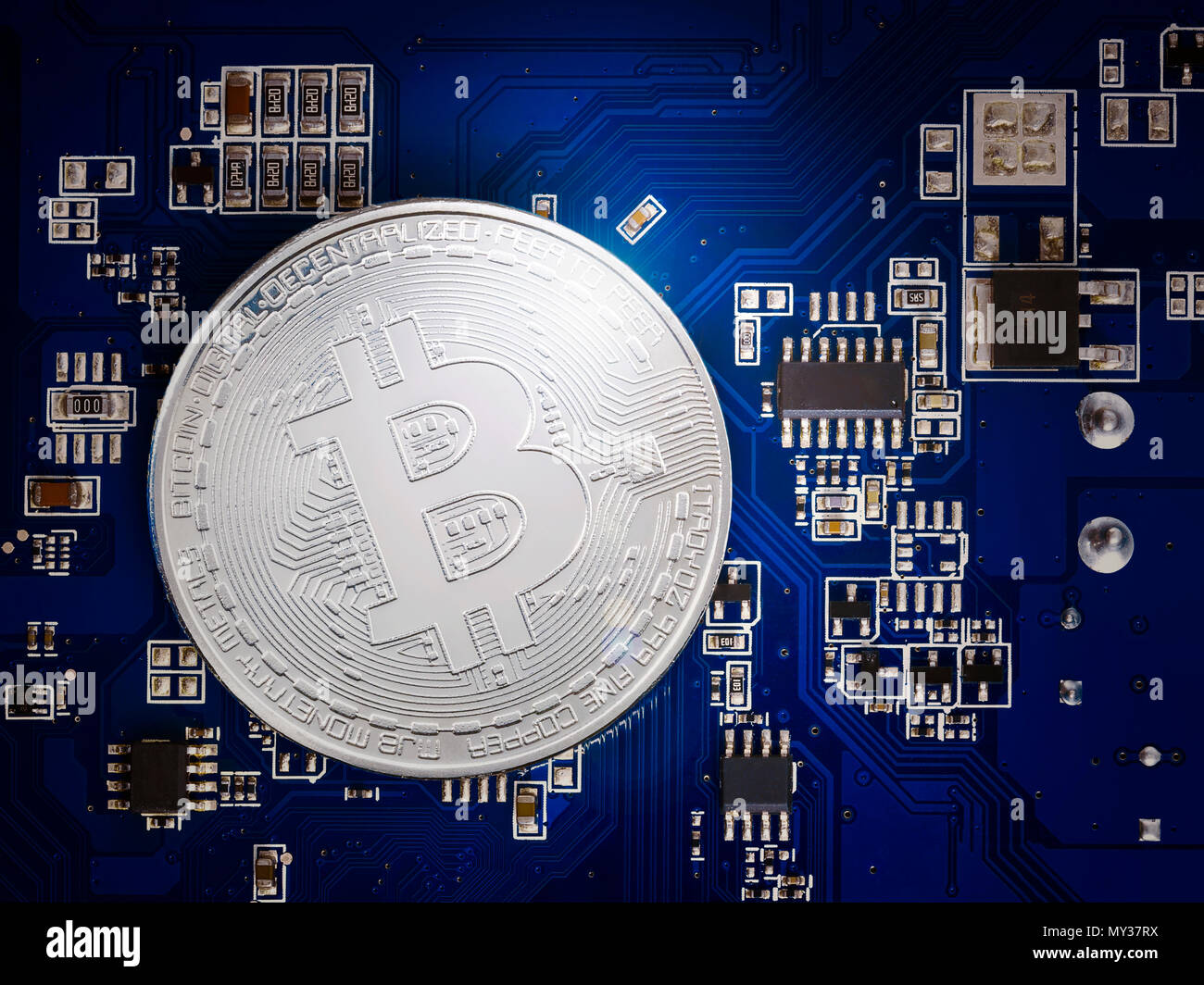 Silver coin of cryptocurrency, bitcoin. Blue and microchip electronic ...