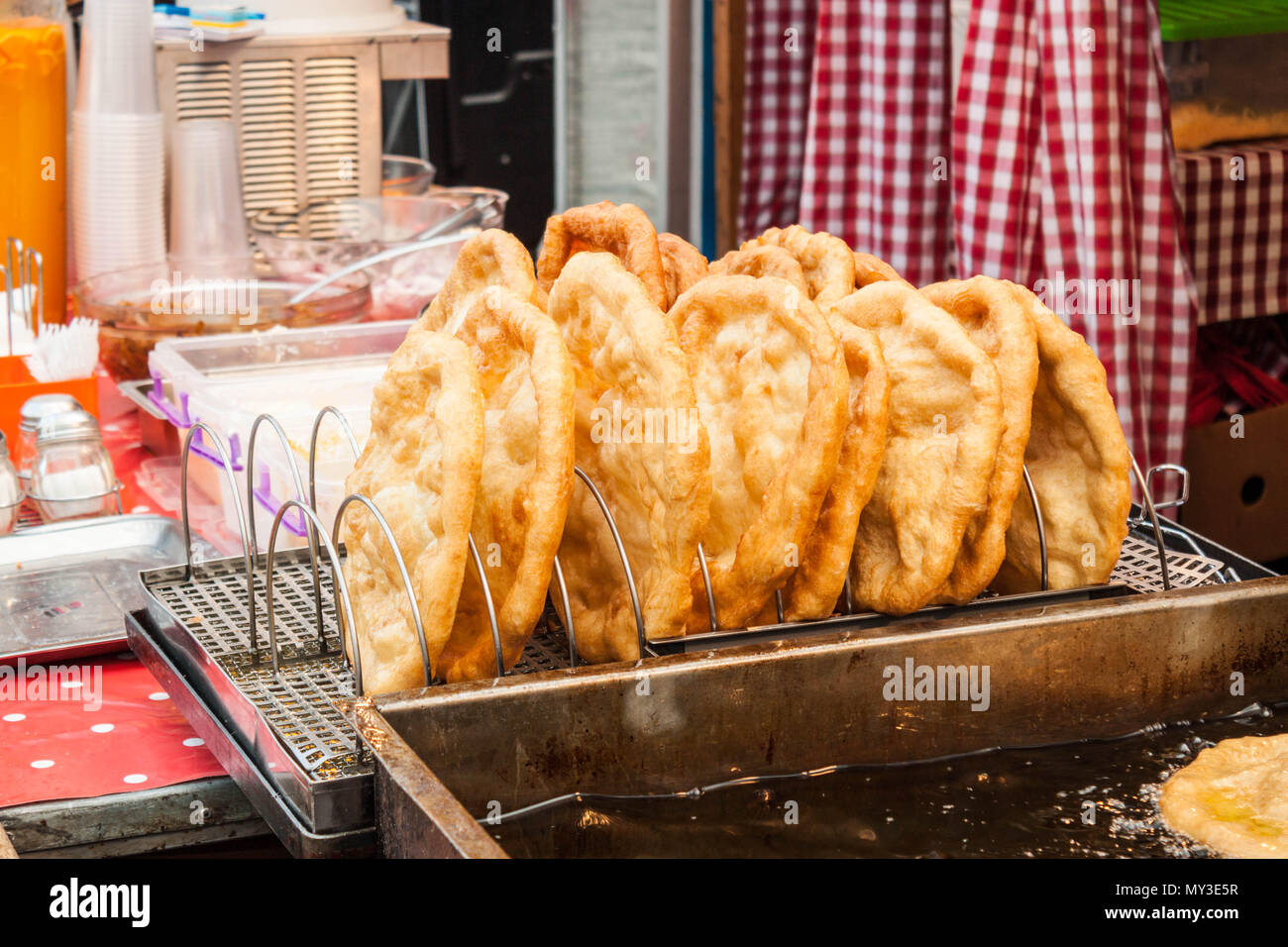 Traditional hungarian fried bread langos. Outdoor market vendor with ...