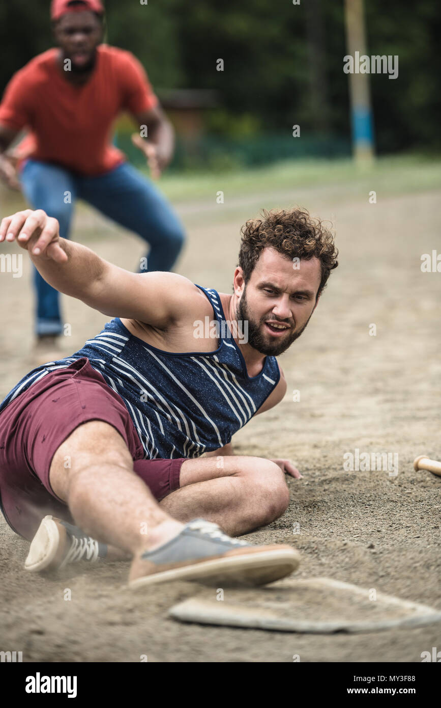 male baseball player reaching base during game on court Stock Photo - Alamy