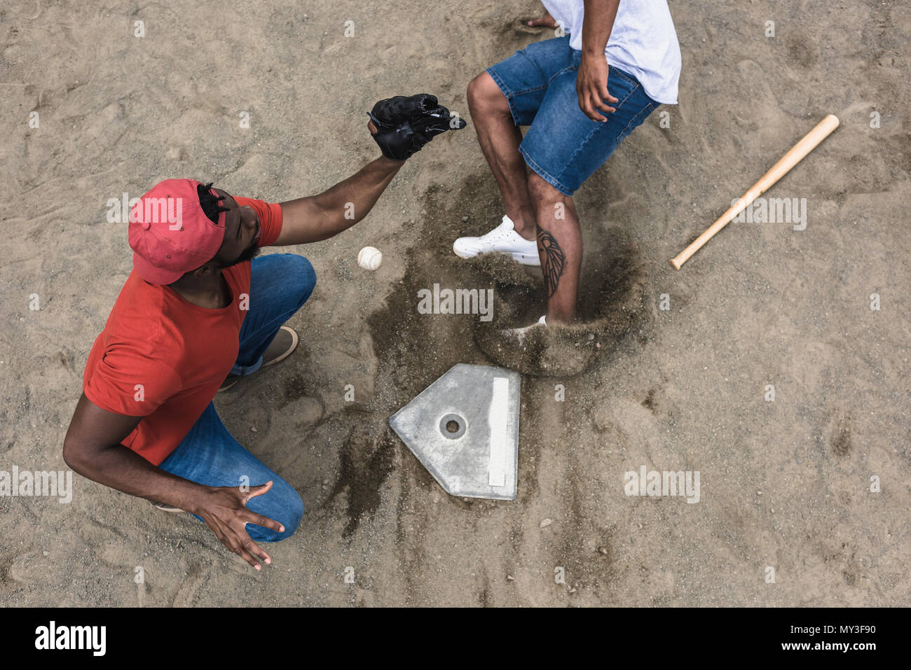 baseball player reaching base during game on court Stock Photo - Alamy