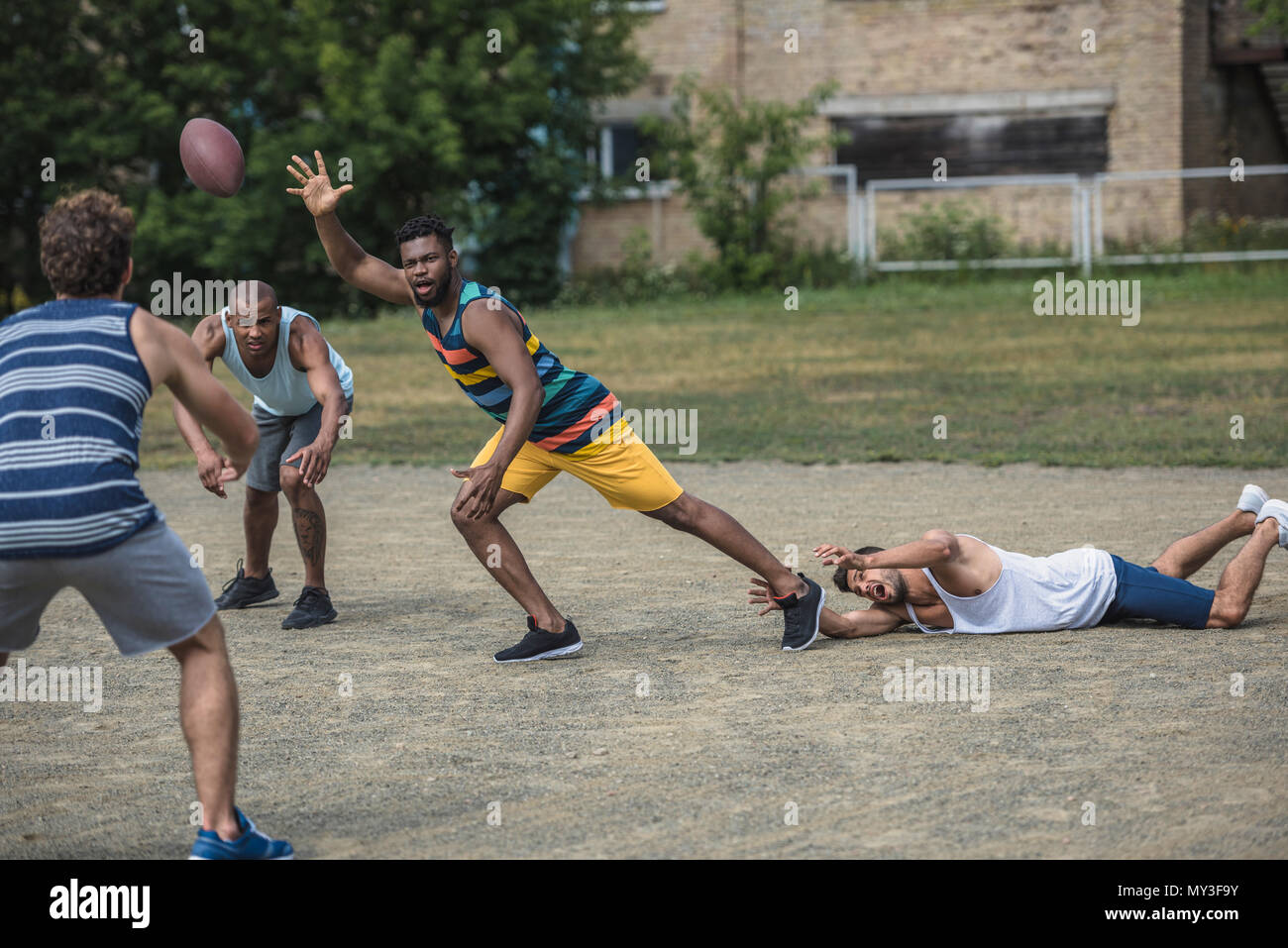 group of young multicultural men playing football on court Stock Photo ...