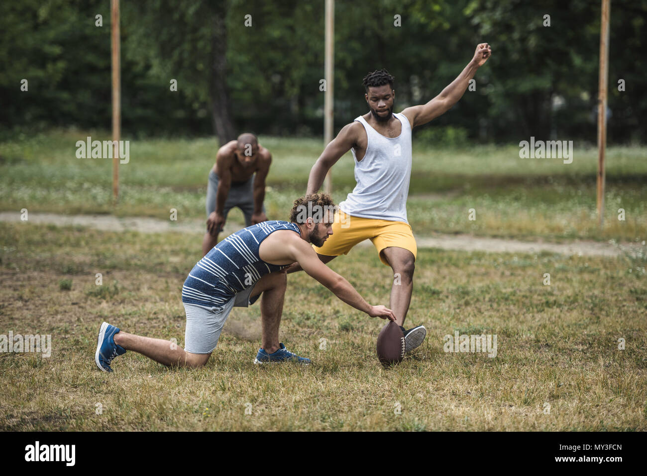 group of young multicultural men playing football on court Stock Photo ...
