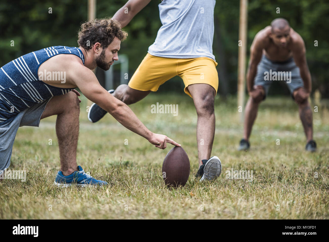 group of young multicultural men playing football on court Stock Photo ...