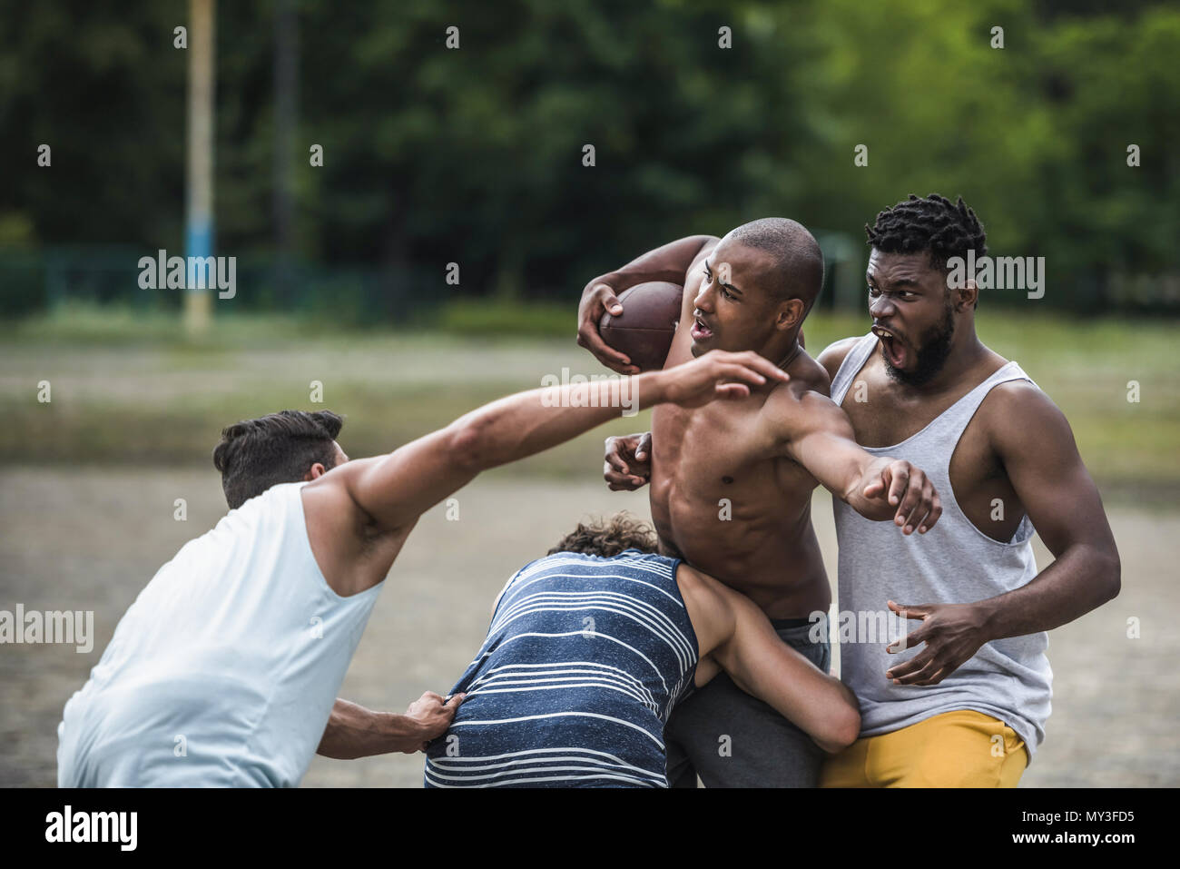group of young multicultural men playing football on court Stock Photo ...