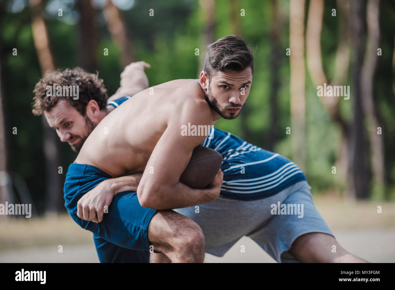 group of young handsome men playing football on court Stock Photo - Alamy