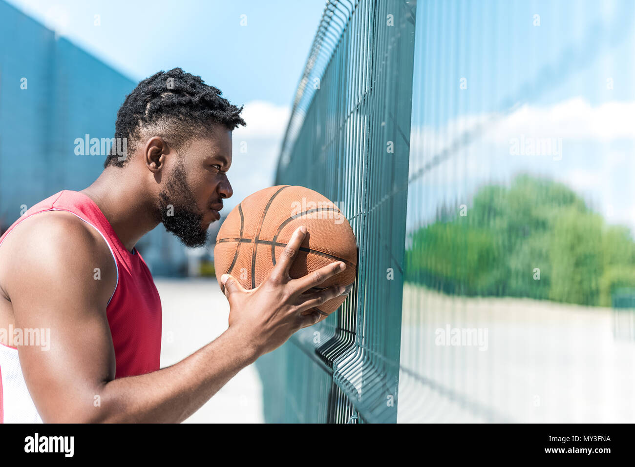 side view of african american basketball player holding ball in hands Stock Photo - Alamy