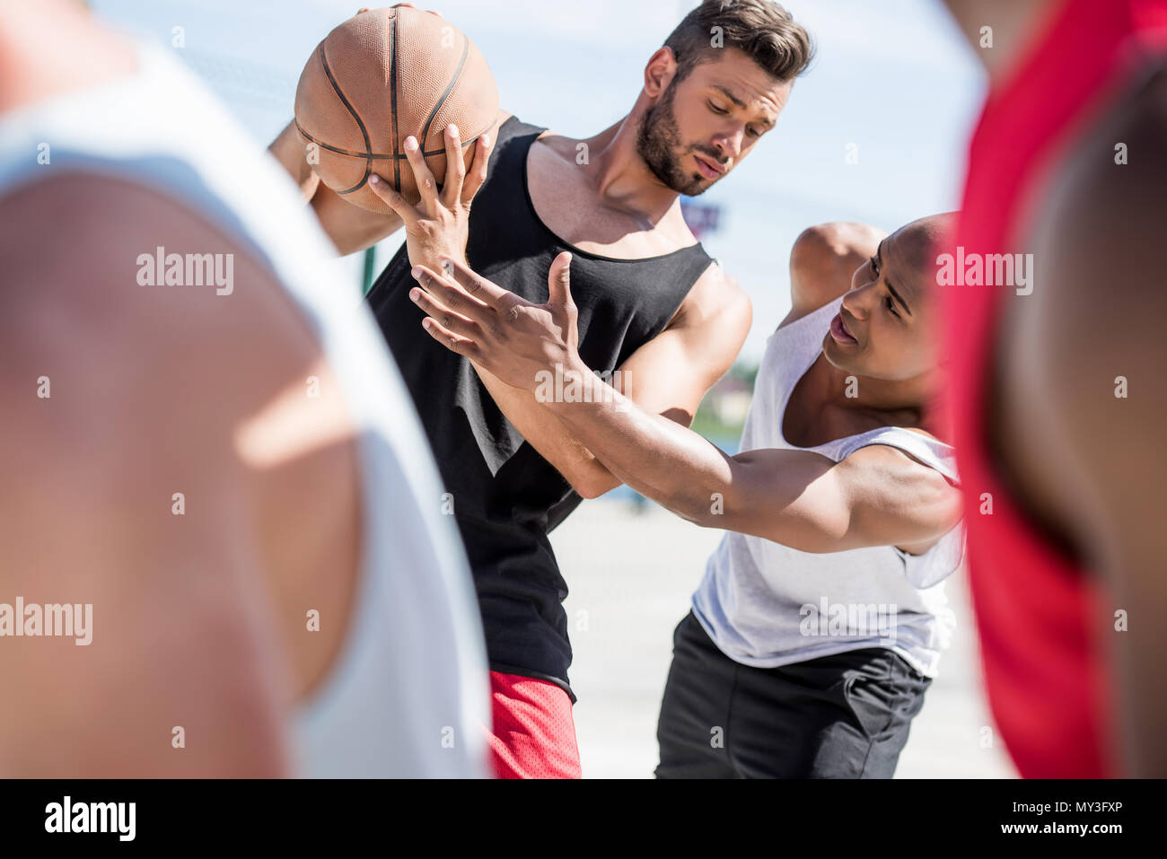 selective focus of multicultural basketball players during game on ...