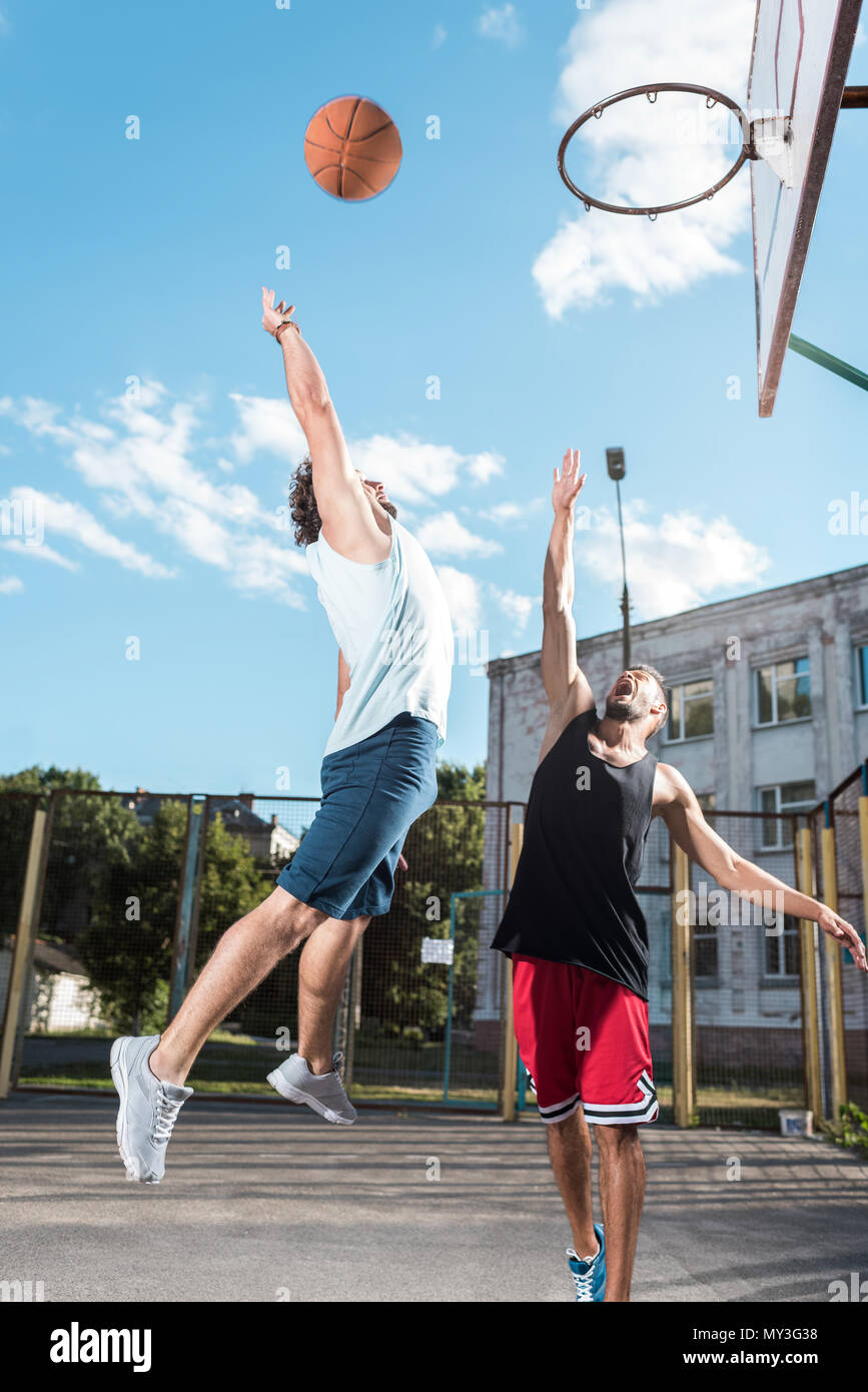 athletic basketball players playing basketball together on court Stock ...