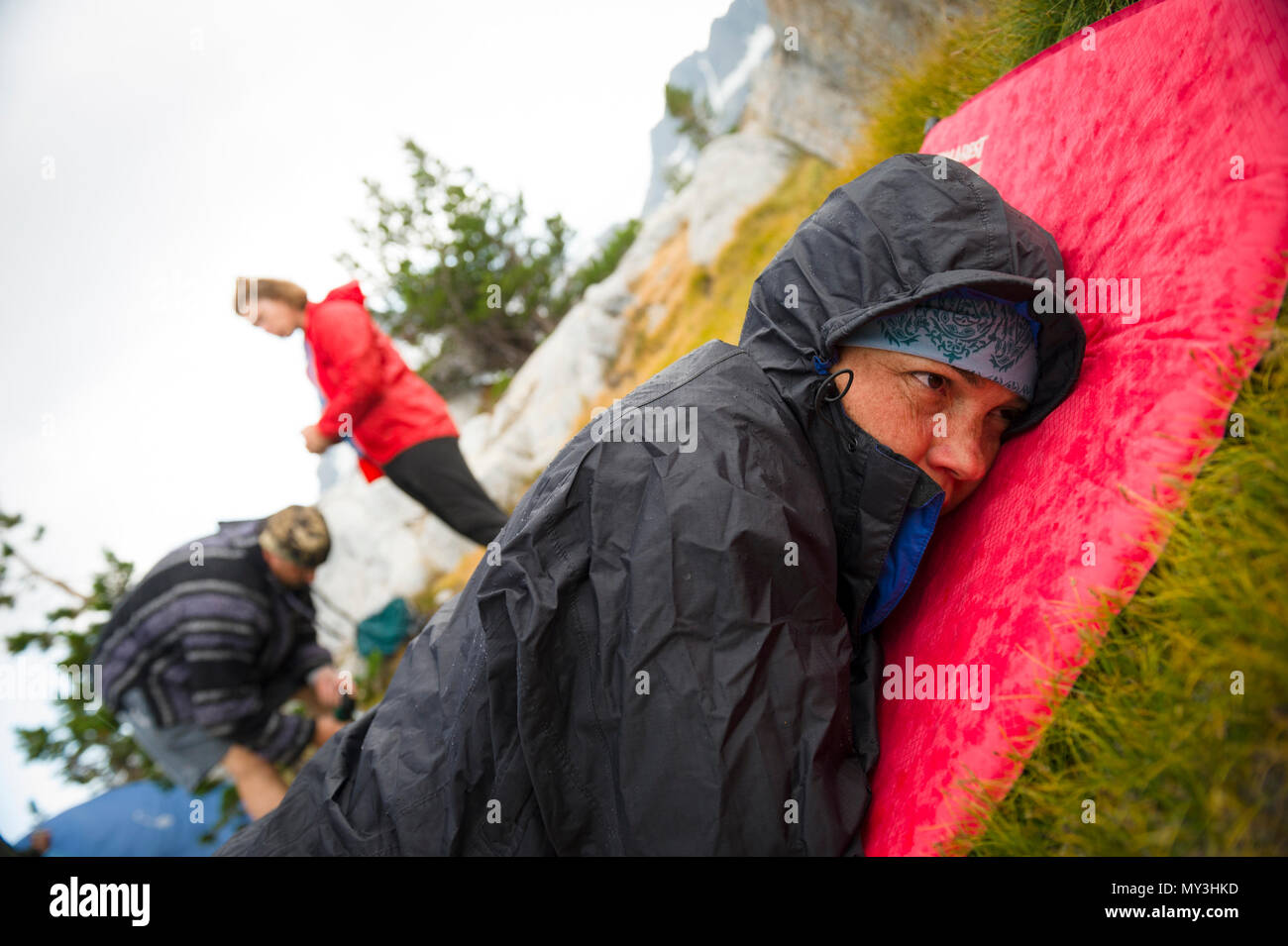Exhausted hiker resting in the rain during a high sierra hike into the ...
