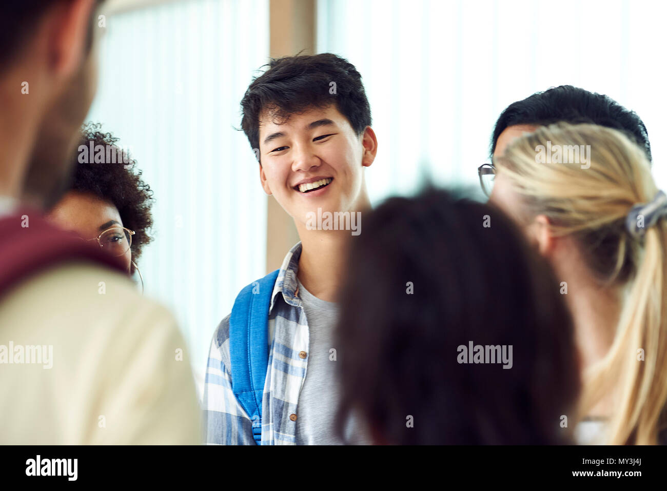 Classmates talking together in corridor Stock Photo - Alamy