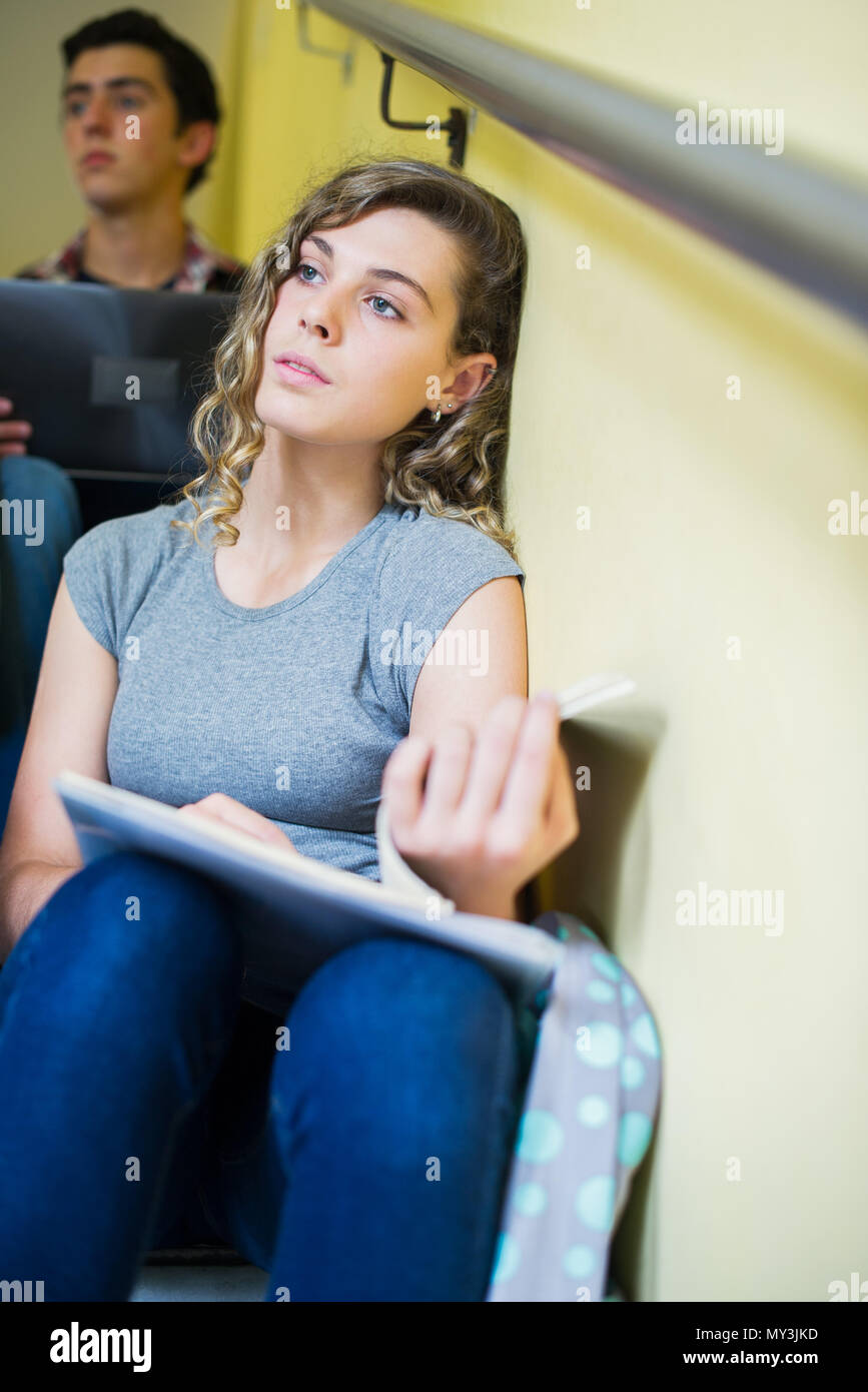 Student daydreaming while studying on stairs Stock Photo - Alamy