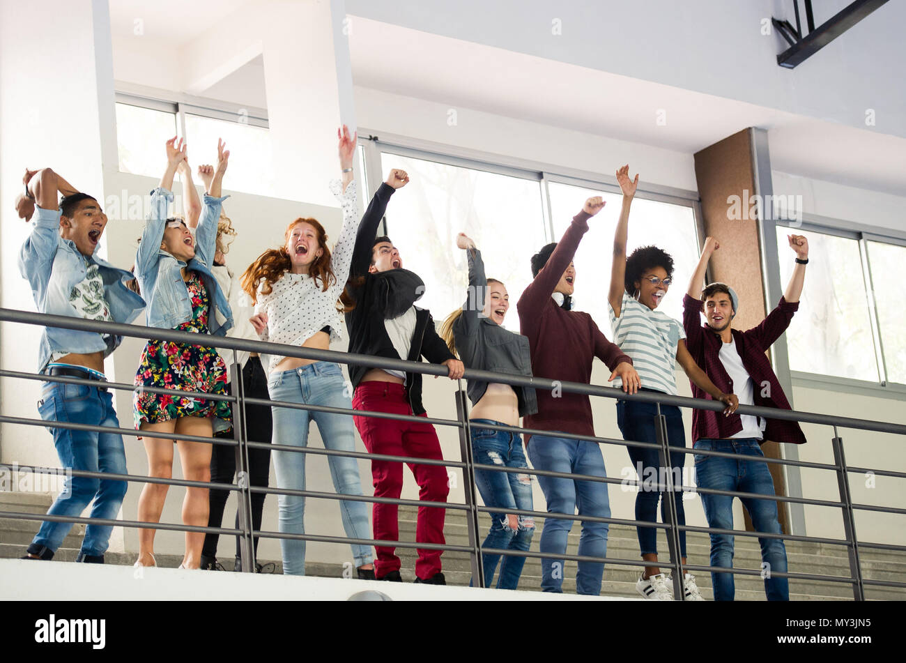 Group of students cheering while watching sports event at school Stock ...