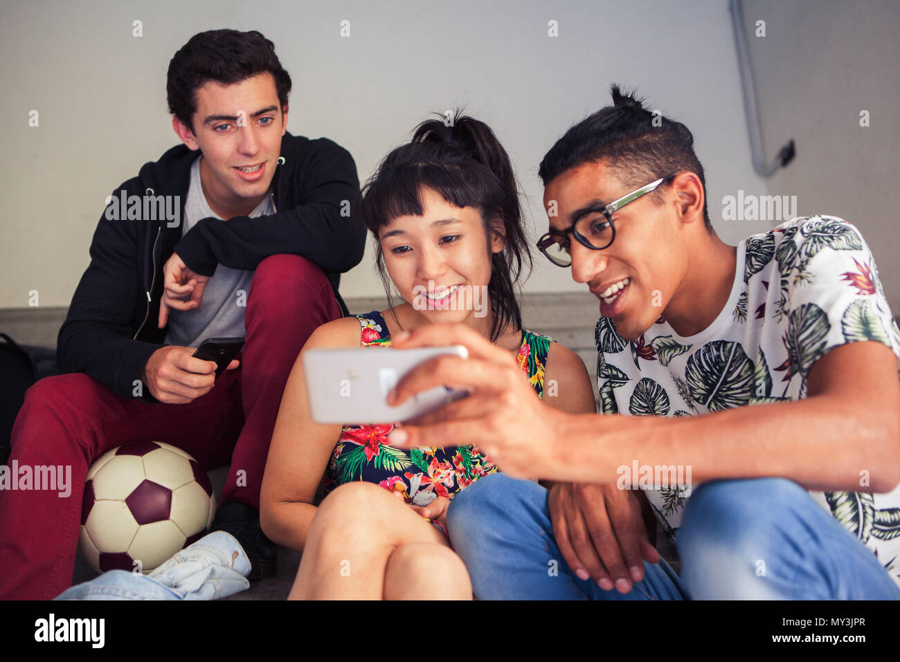 School friends looking at smartphone together Stock Photo - Alamy