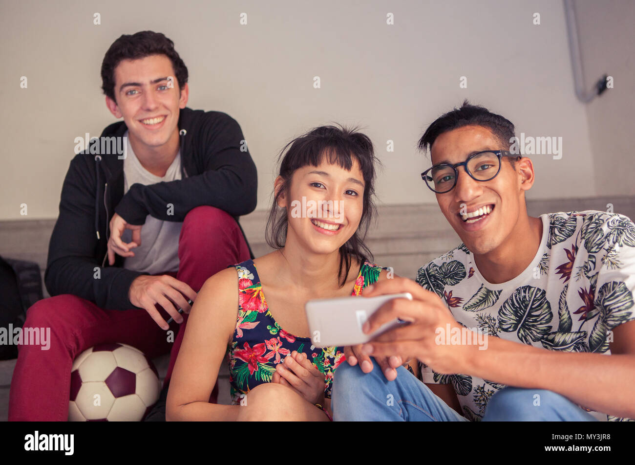 Friends hanging out and using smartphone together Stock Photo - Alamy