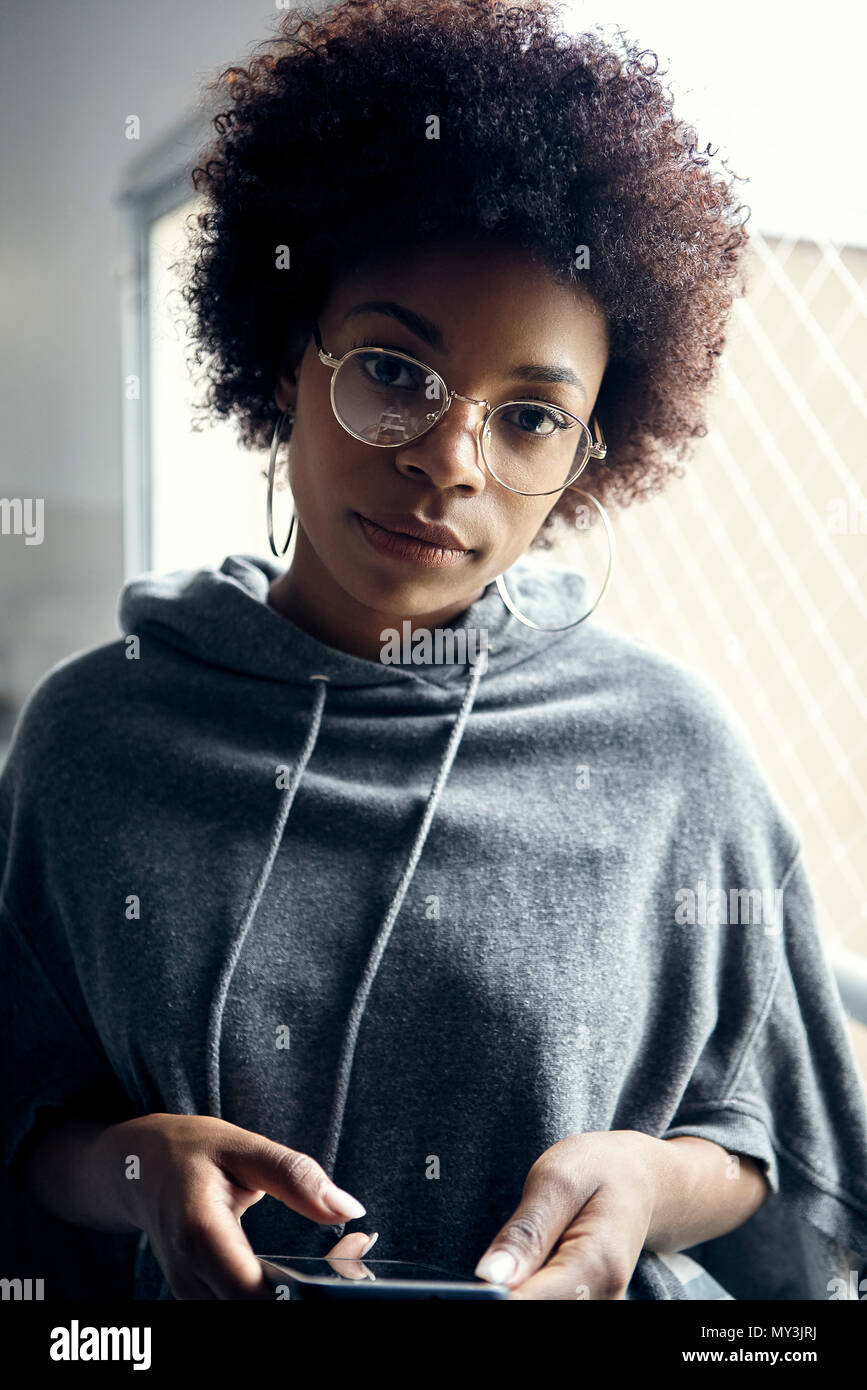 Young woman holding smartphone, portrait Stock Photo - Alamy