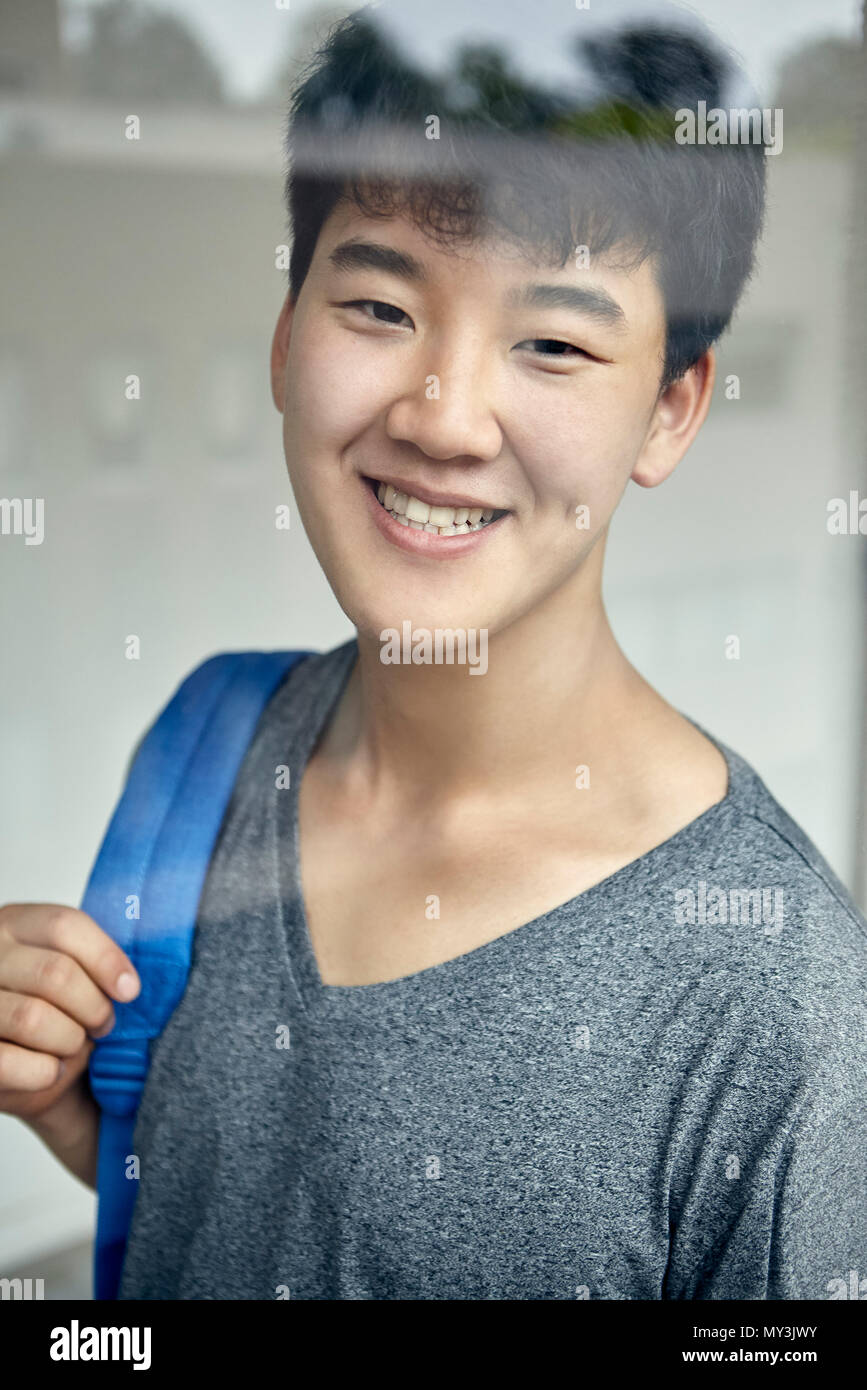 Young man smiling through window, portrait Stock Photo - Alamy