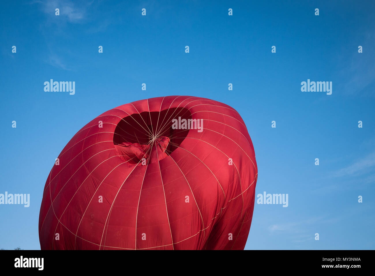 A hot air balloon canopy is slowly inflated prior to an evening ride ...