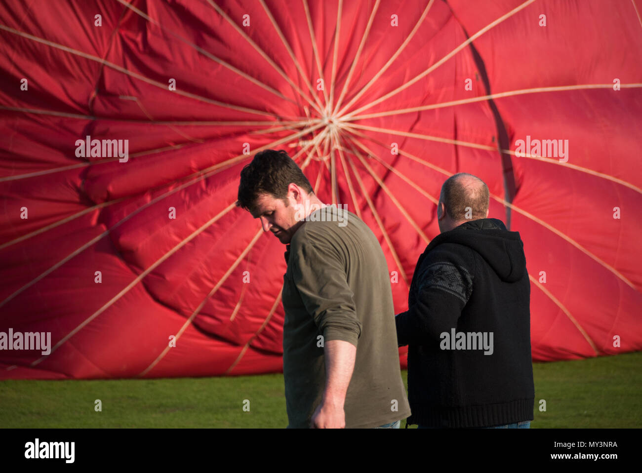 Two men controlling a hot air balloon being inflated on the Kanvesmire ...