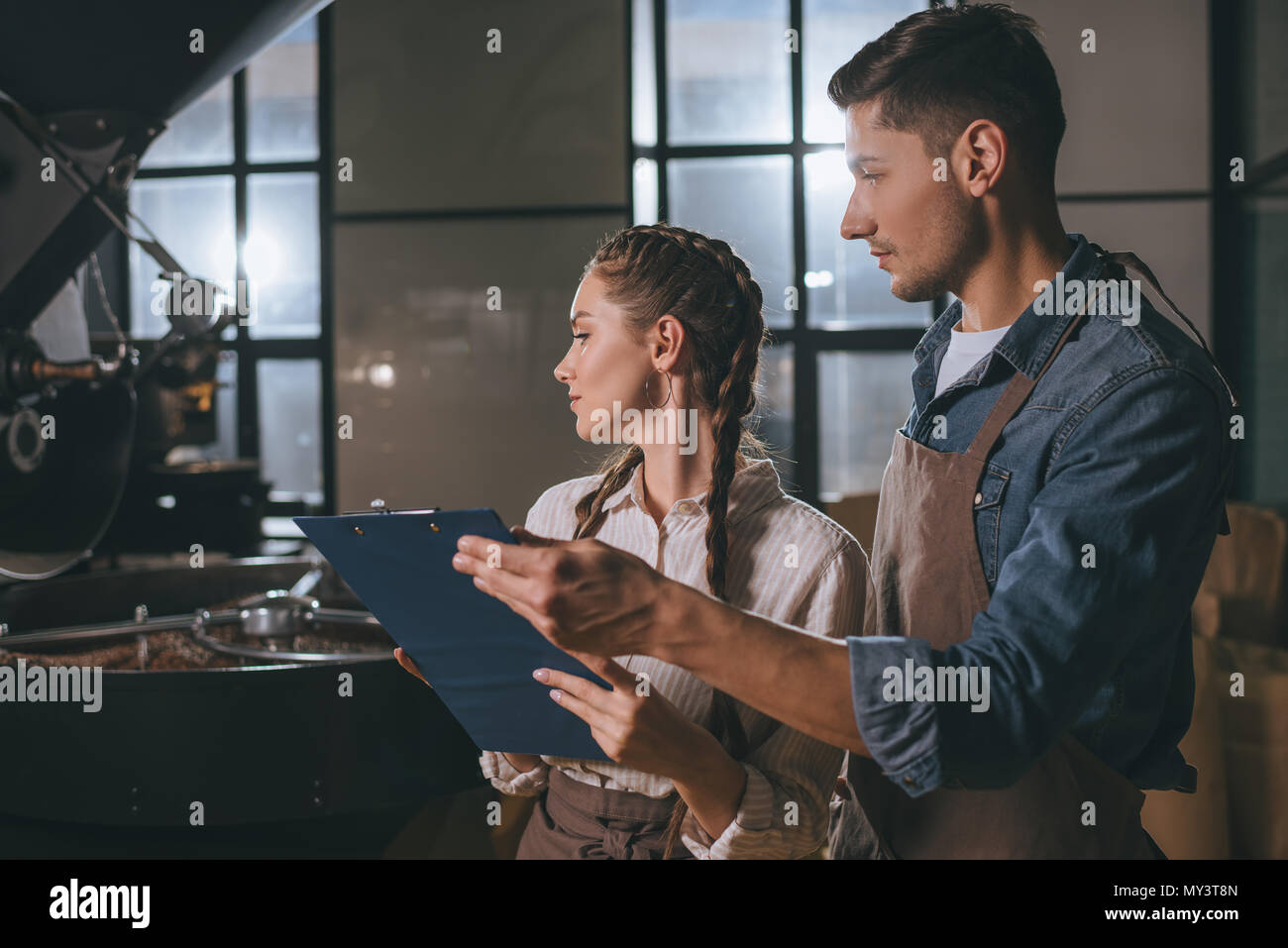 portrait of coffee shop workers checking coffee beans roasting process ...