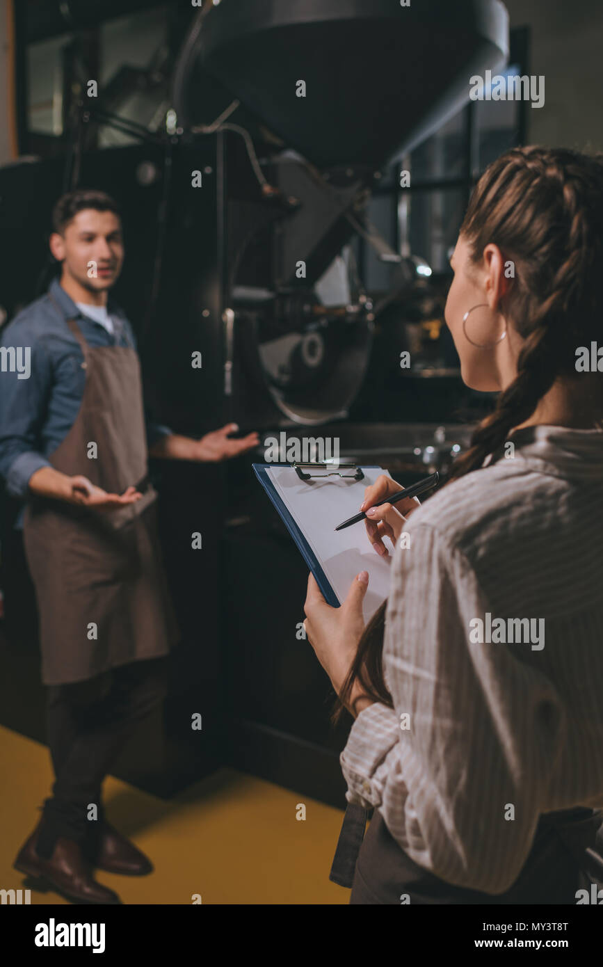 selective focus of woman checking colleagues work during coffee ...