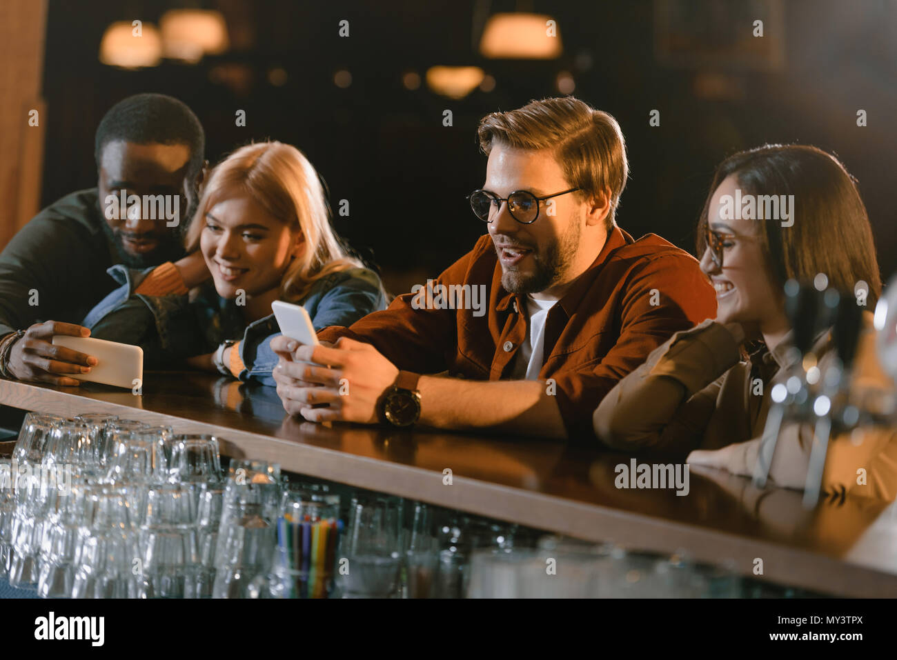 company of young people using smartphones at bar Stock Photo - Alamy