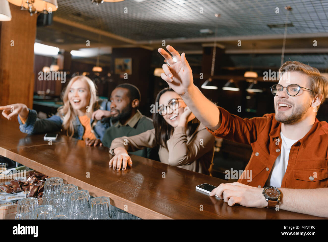 young people at bar counter calling barman Stock Photo - Alamy