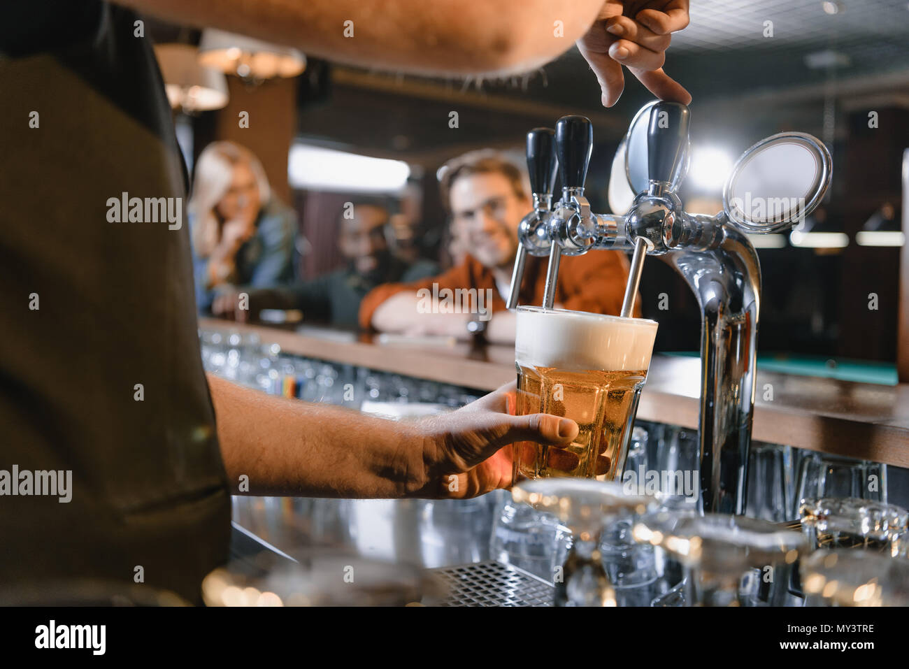 cropped image of barman pouring beer in glass at bar Stock Photo - Alamy