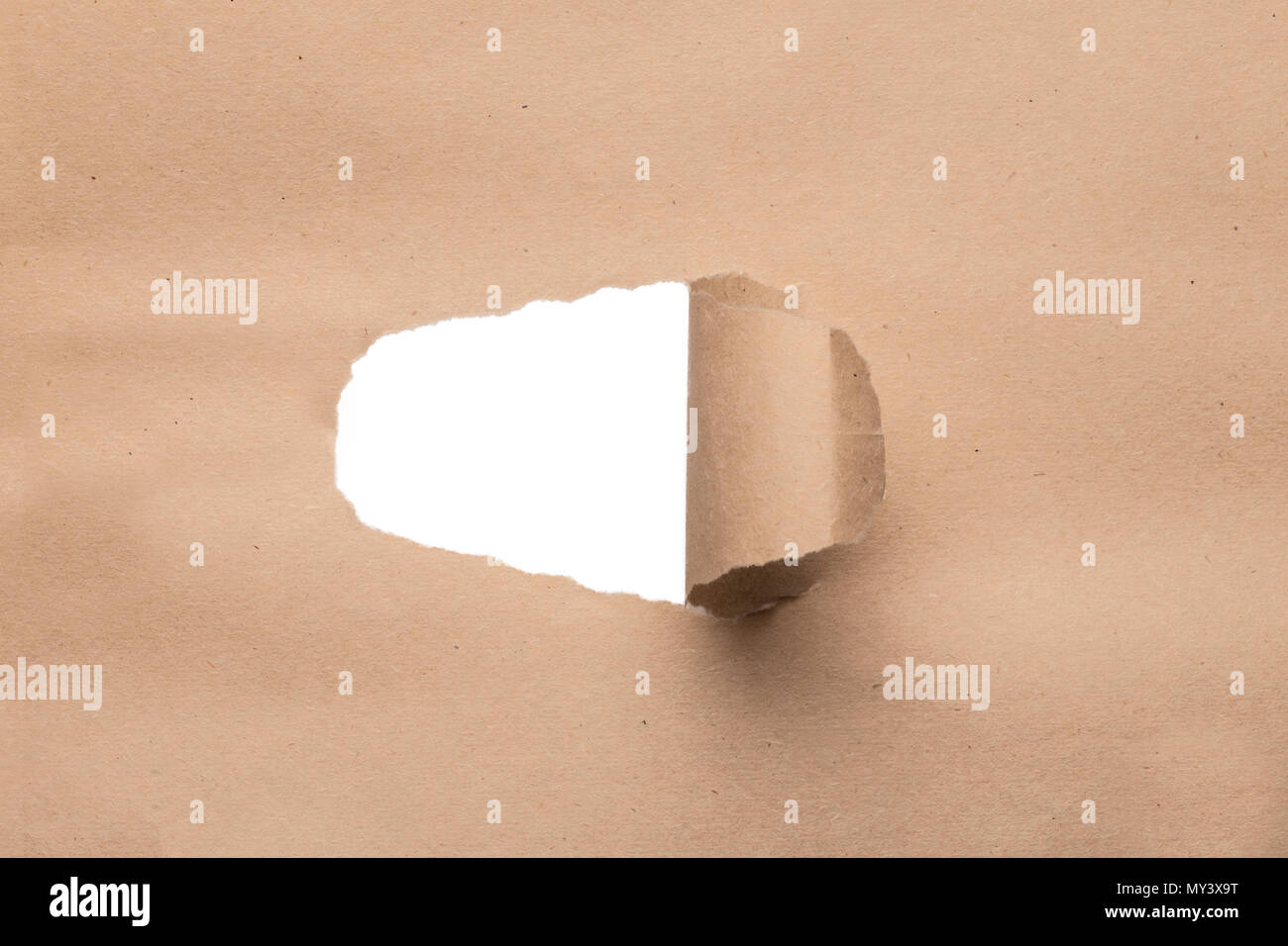 holes in brown paper with torn sides over paper background with space ...