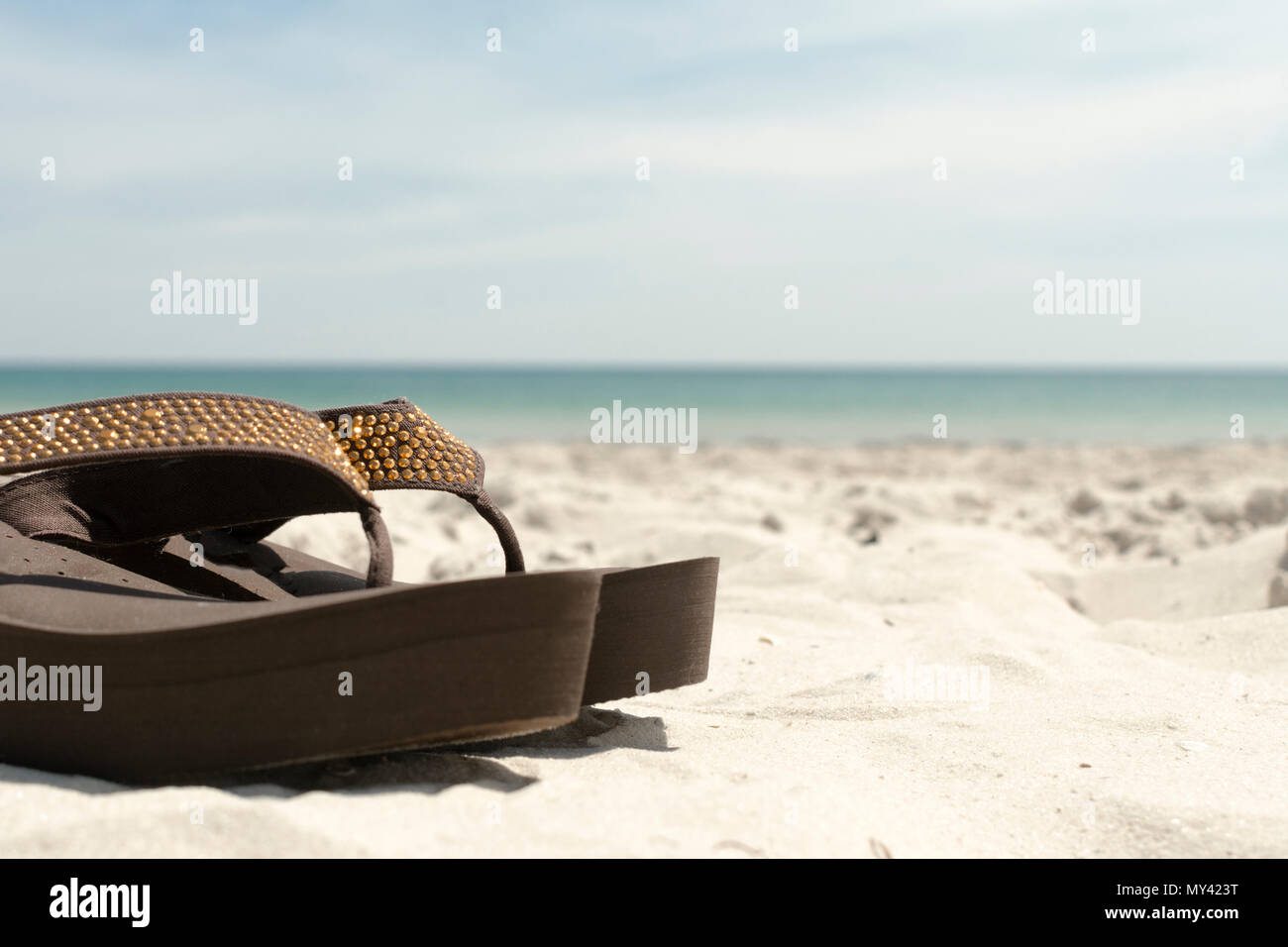 Flip flops in the sand on sea beach background Stock Photo - Alamy