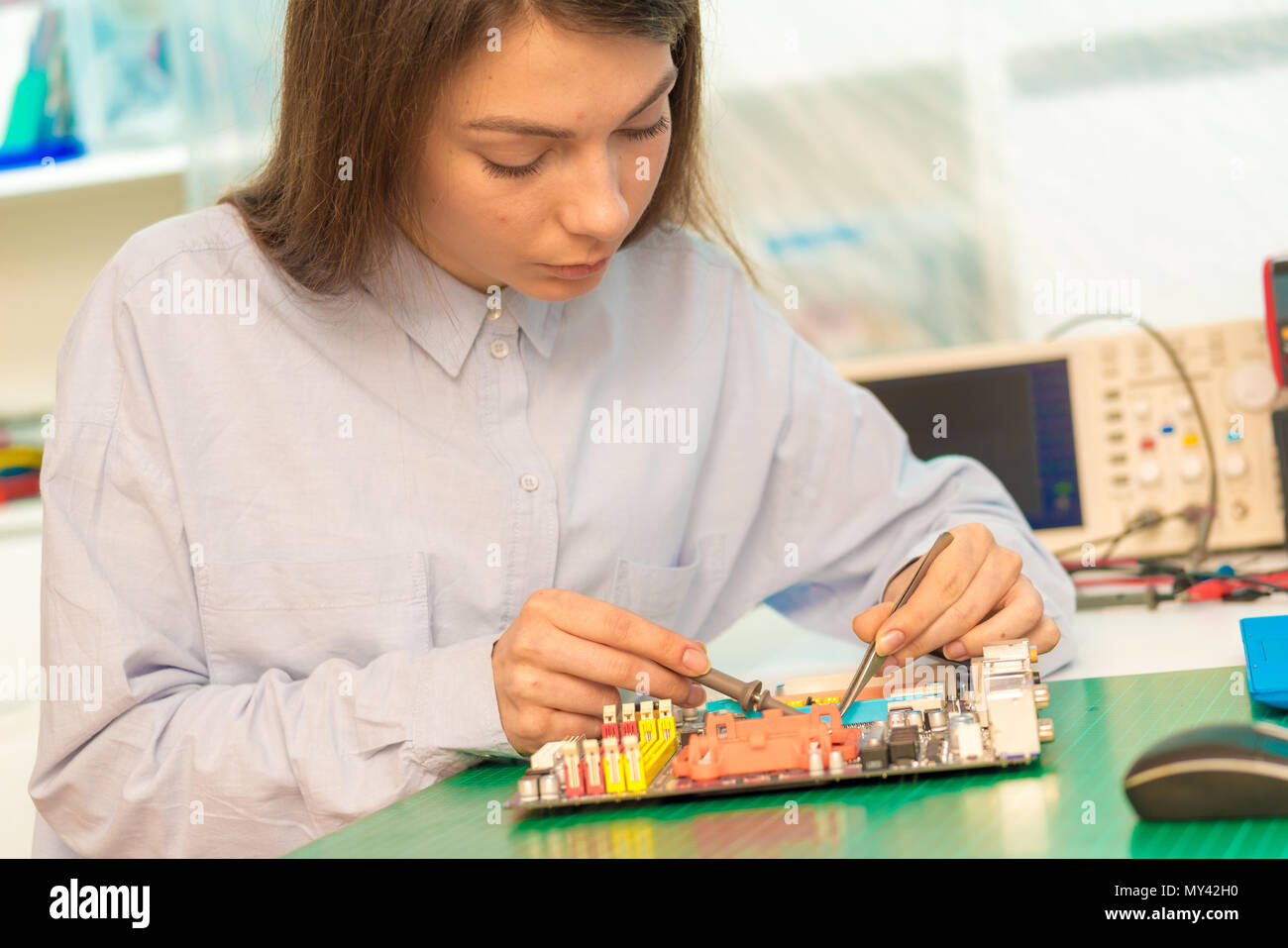 Female student in electronics class uses a Measuring device Stock Photo ...