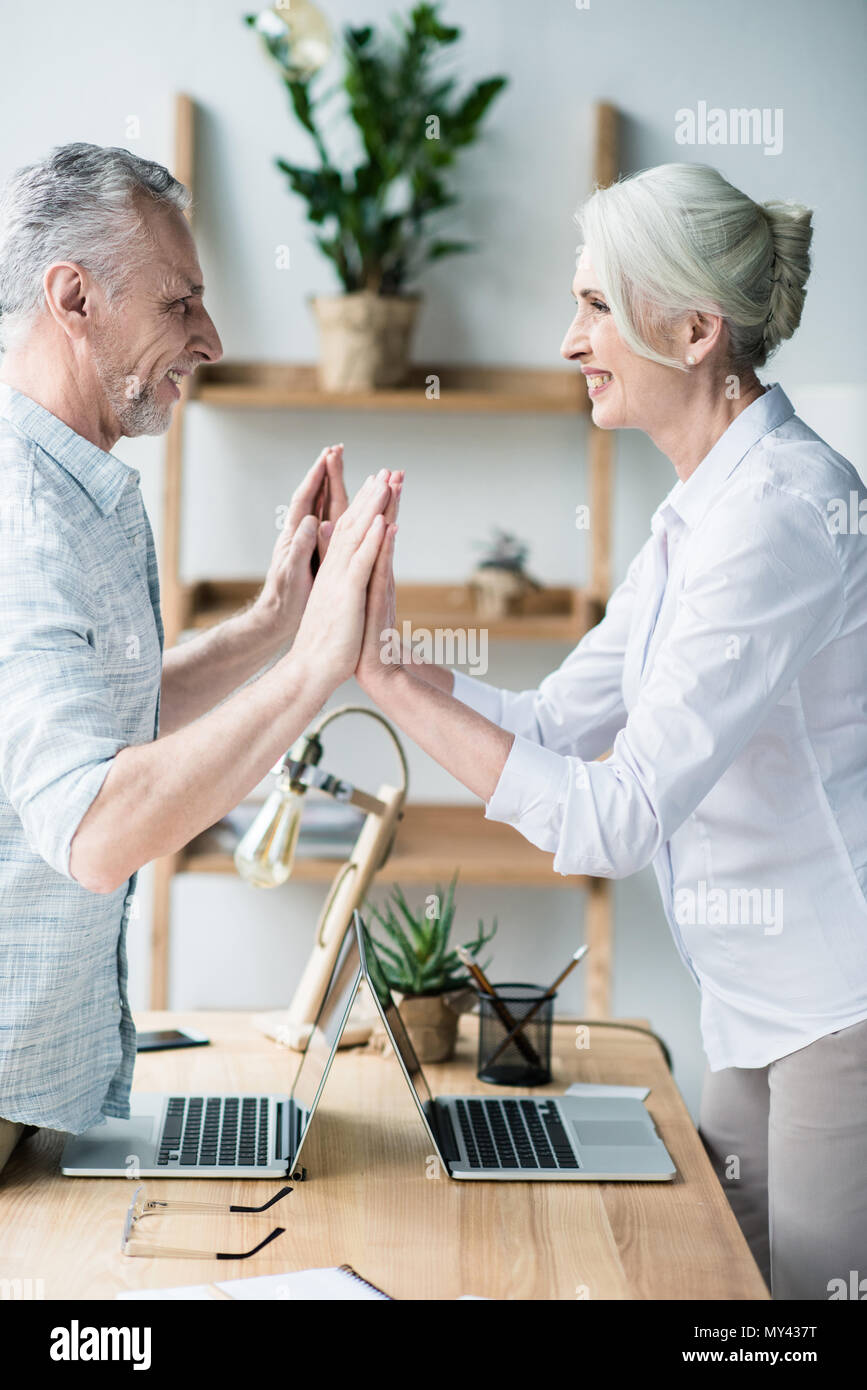 Business people giving double high five to each other Stock Photo - Alamy