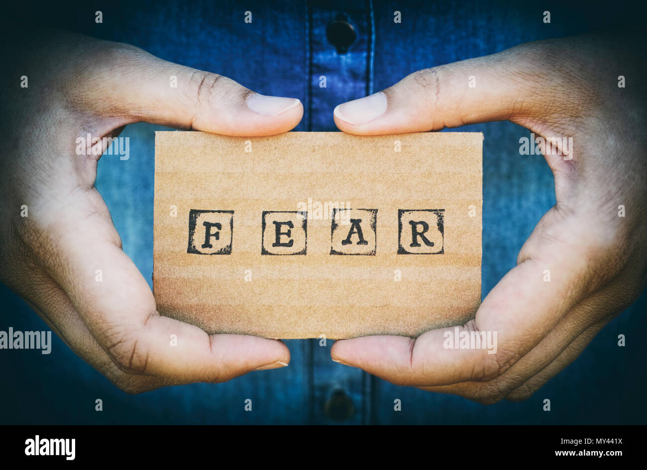 Woman hand holding cardboard card with word Fear made by black alphabet ...