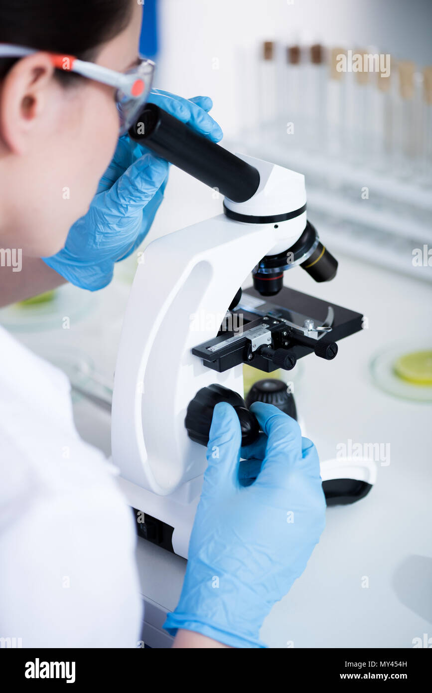 Female scientist during work with microscope at modern biological ...