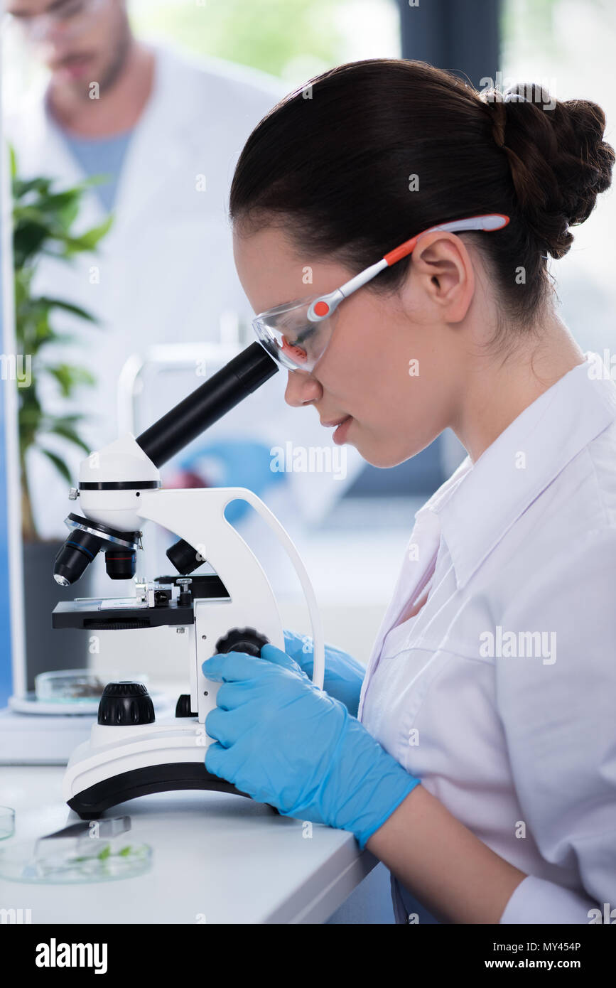 Female scientist during work with microscope at modern biological ...