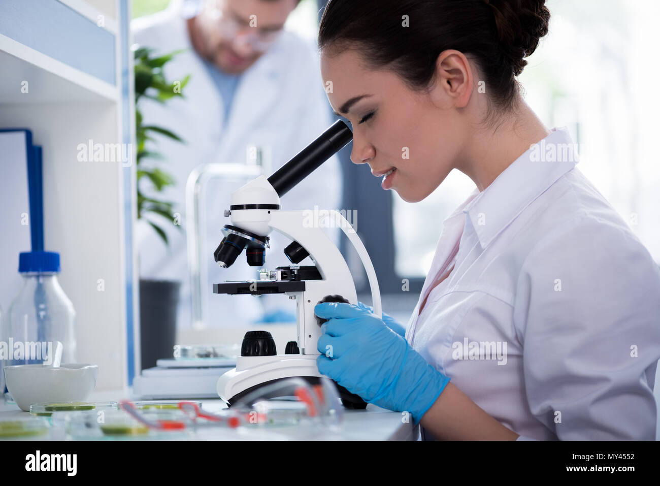 Female scientist during work with microscope at modern biological ...