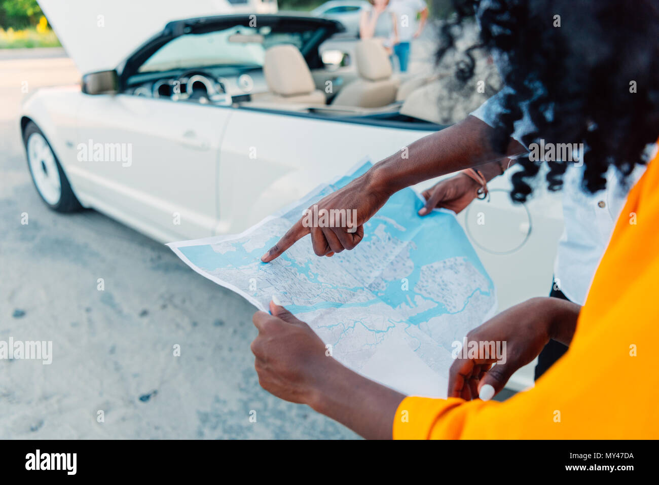 partial view of african american man pointing at map while choosing ...