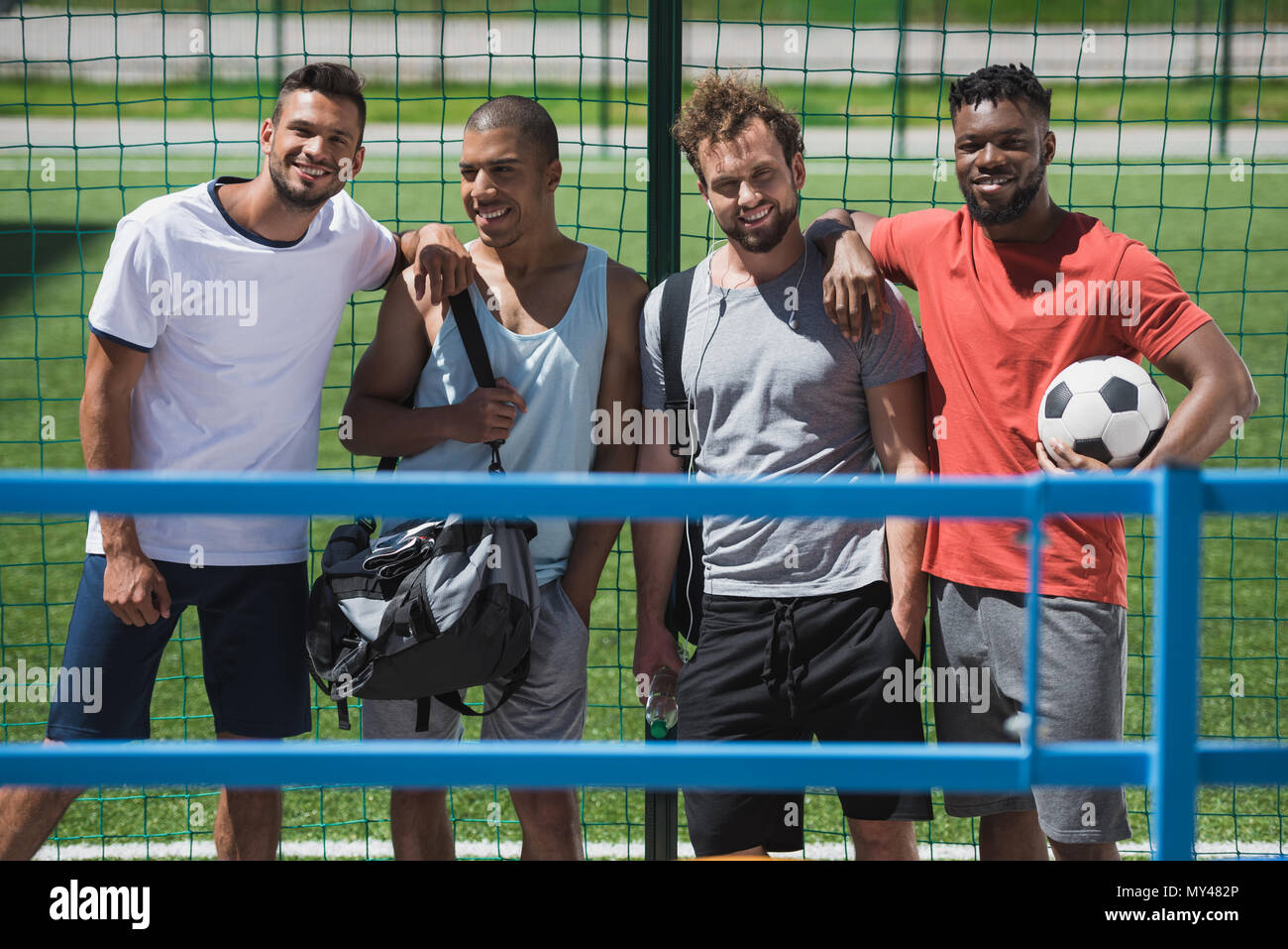 multicultural soccer team resting on stadium together before game Stock ...