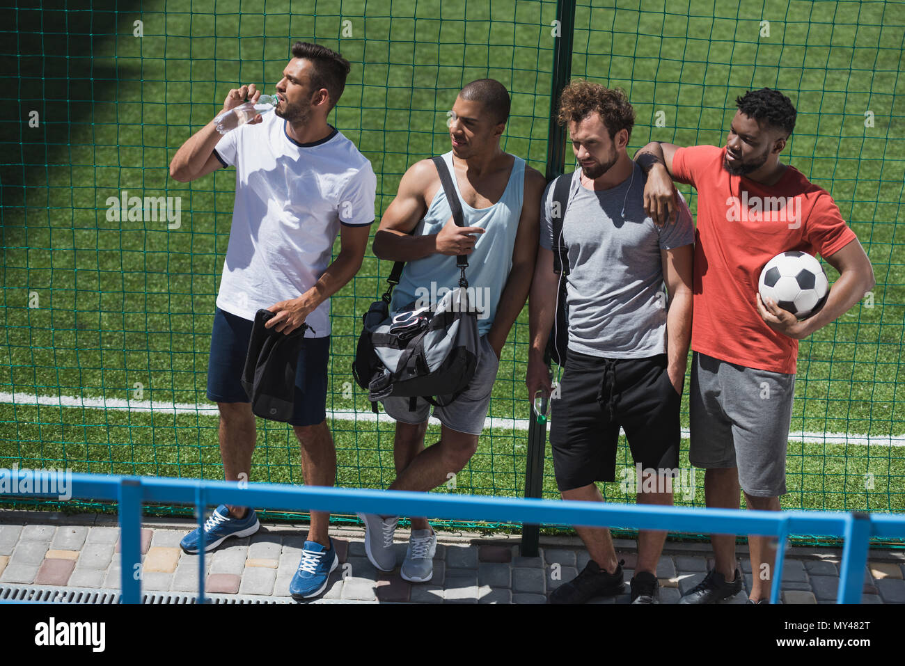 multicultural soccer team resting on stadium together before game Stock ...