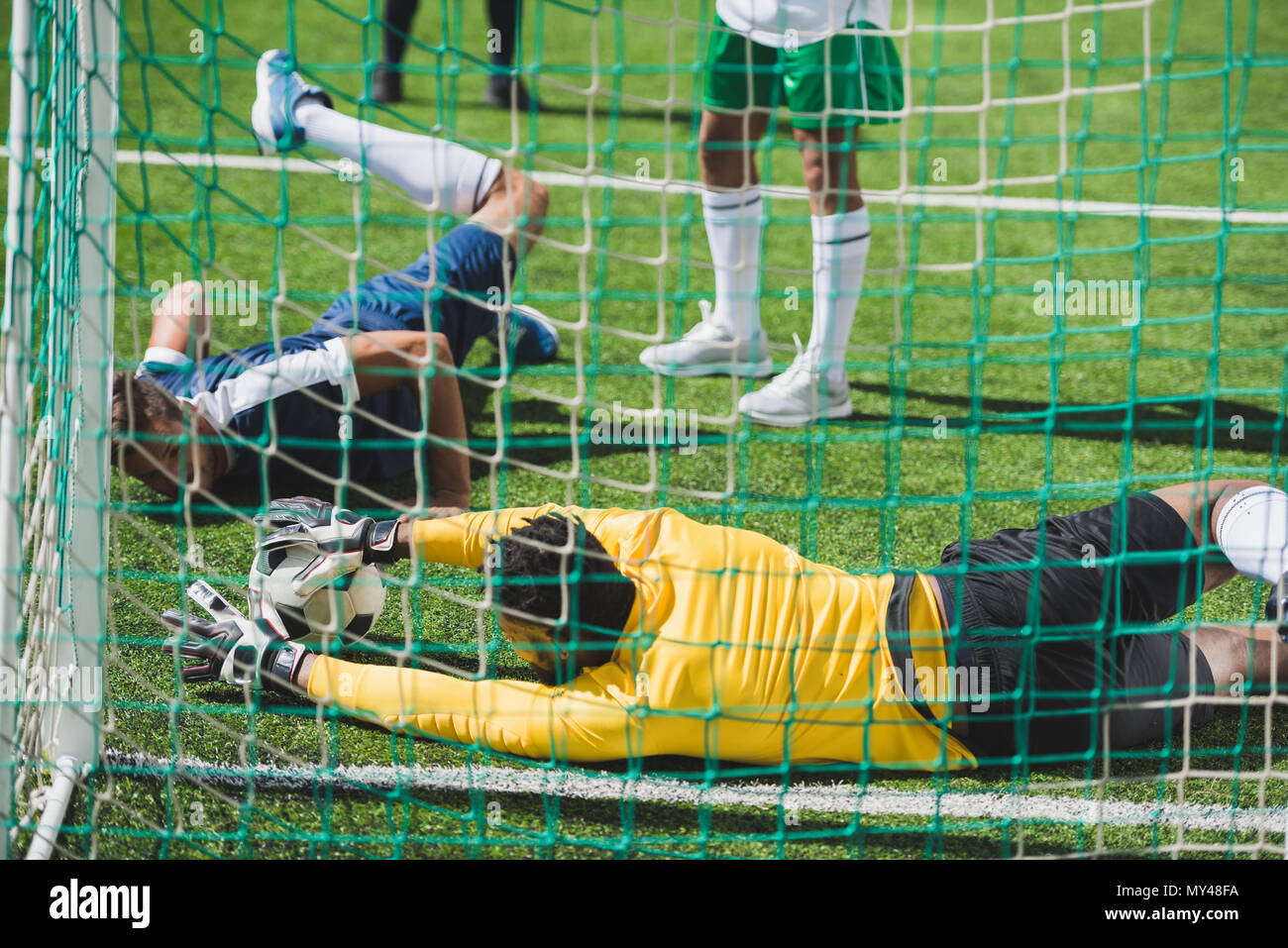 back view of goalkeeper catching ball during soccer game on pitch Stock ...